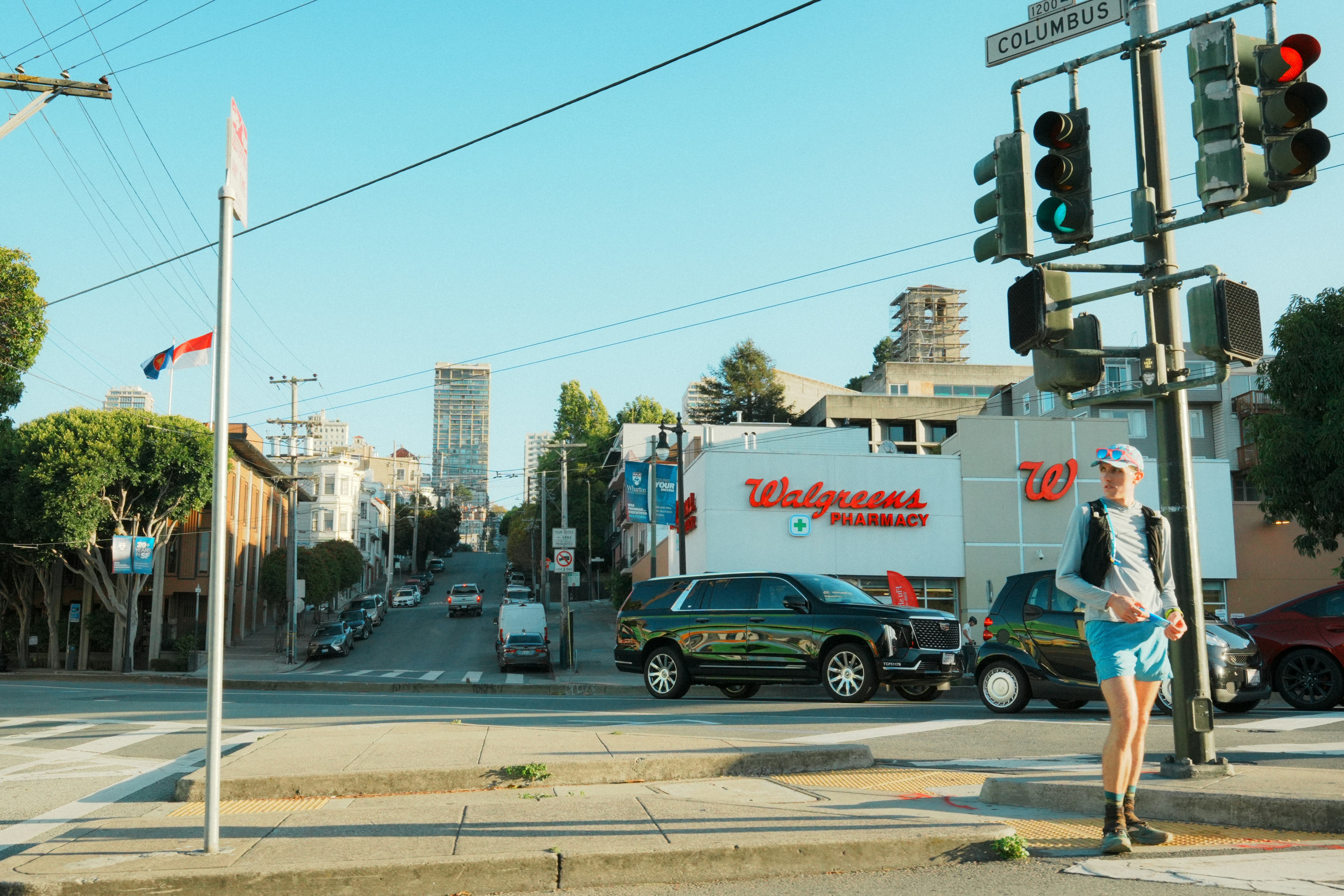 Crosswalk Stance: A Pedestrian Pauses at the City Edge