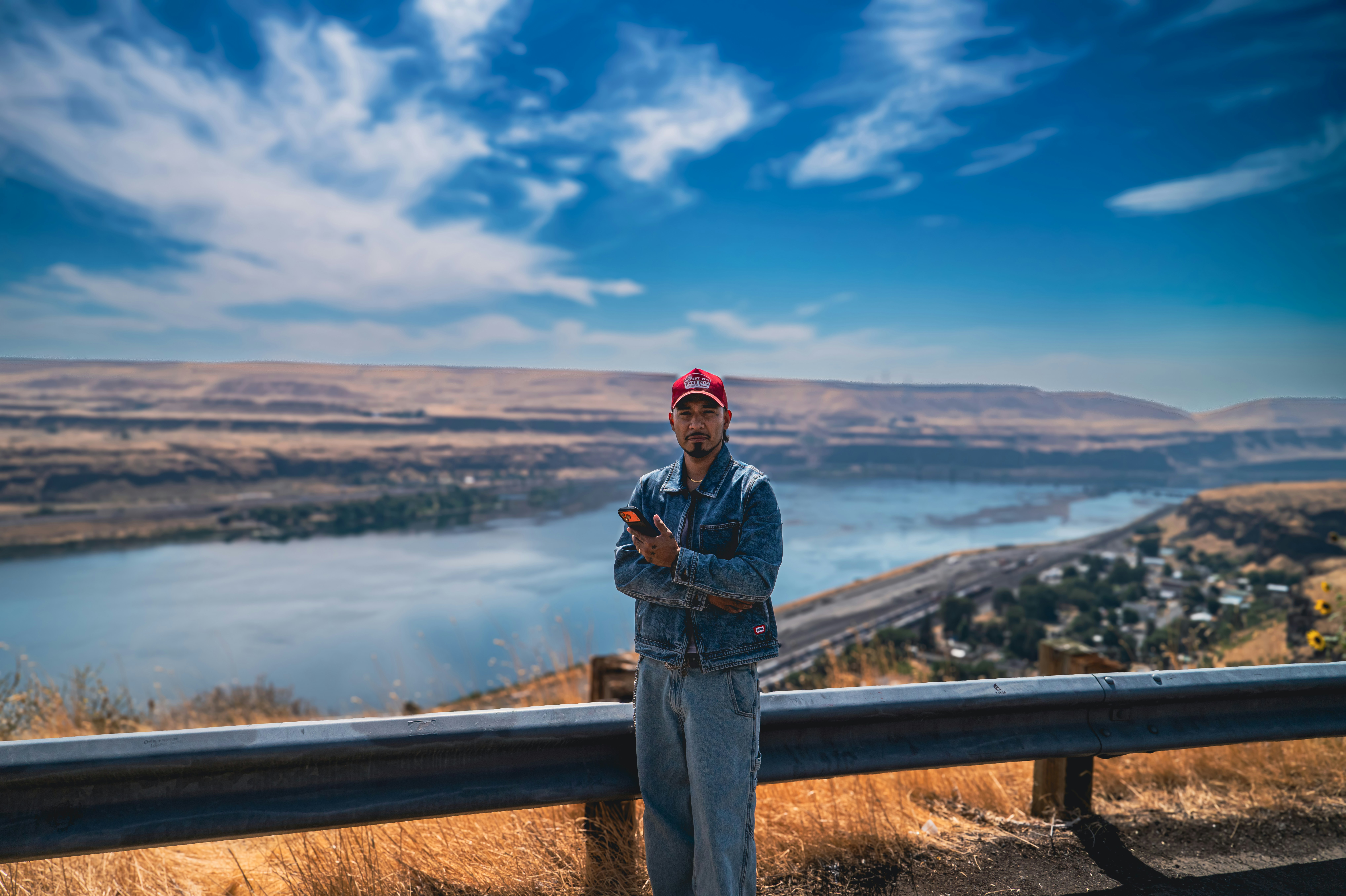 Man in denim by a scenic river valley overlook