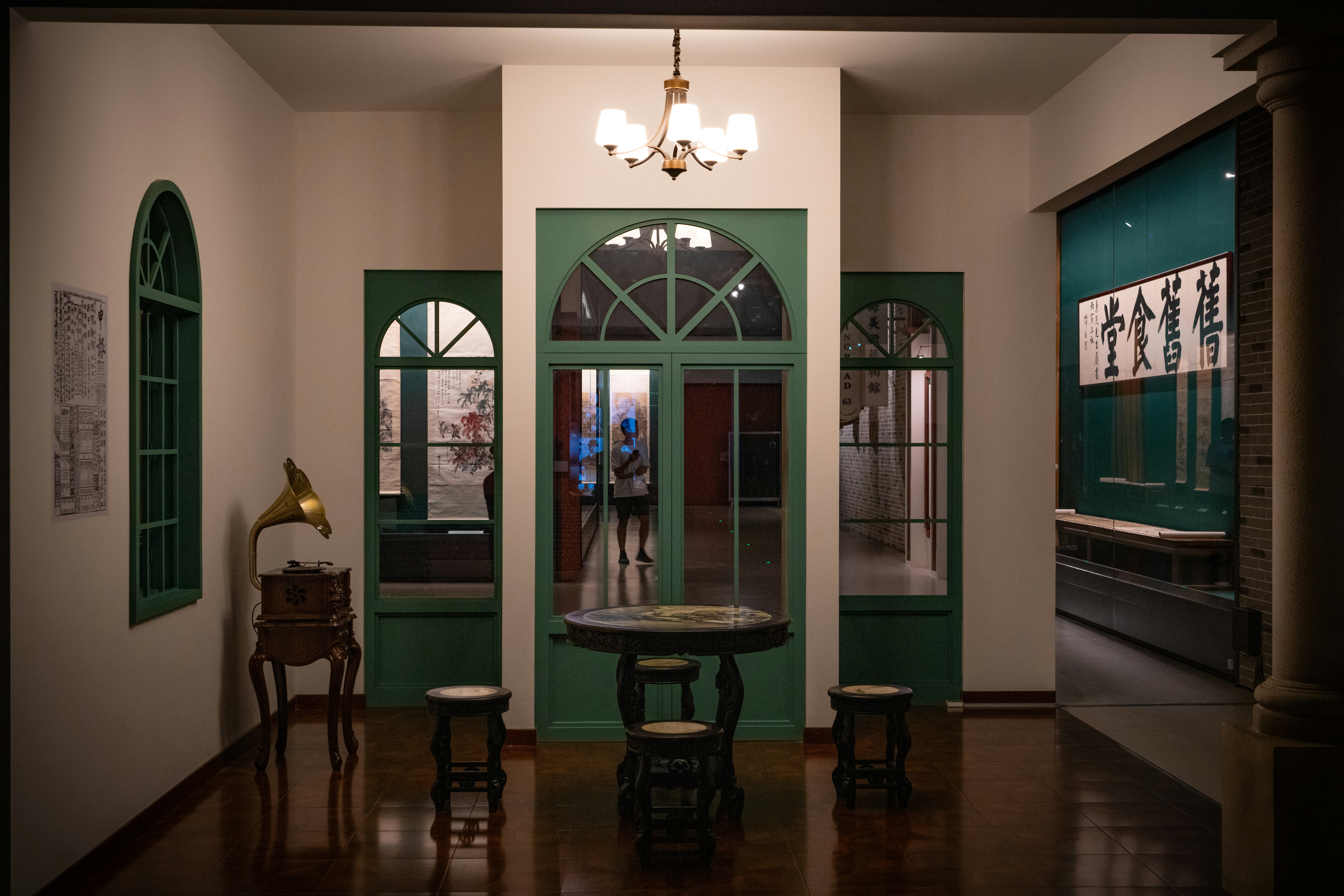 Dim-s illuminated interior with green doors and vintage phonograph