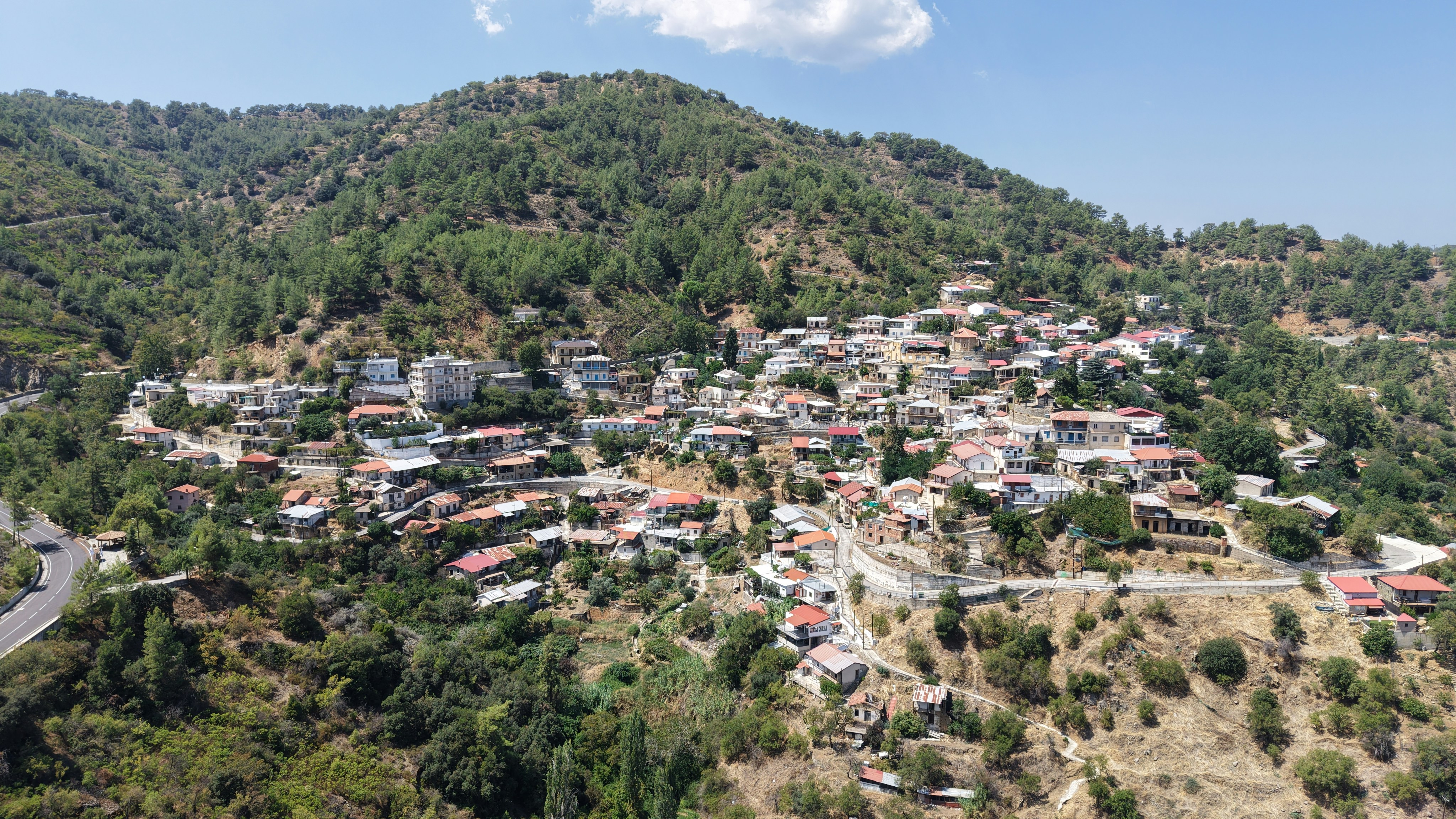 Village Nestled on a Terraced Hill under a Bright Blue Sky