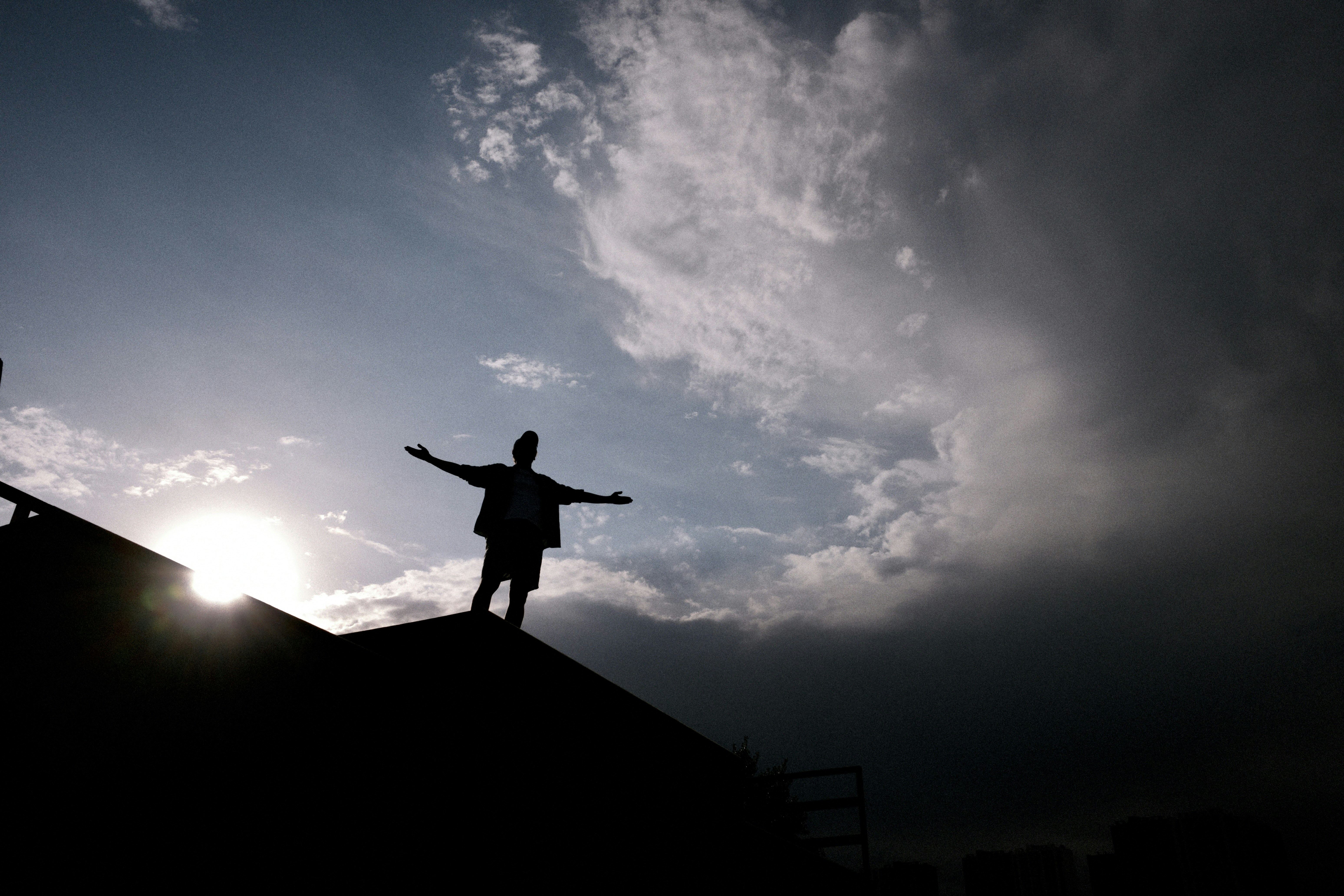 Silhouette on the Ridge: A Figure with Open Arms at Sunset