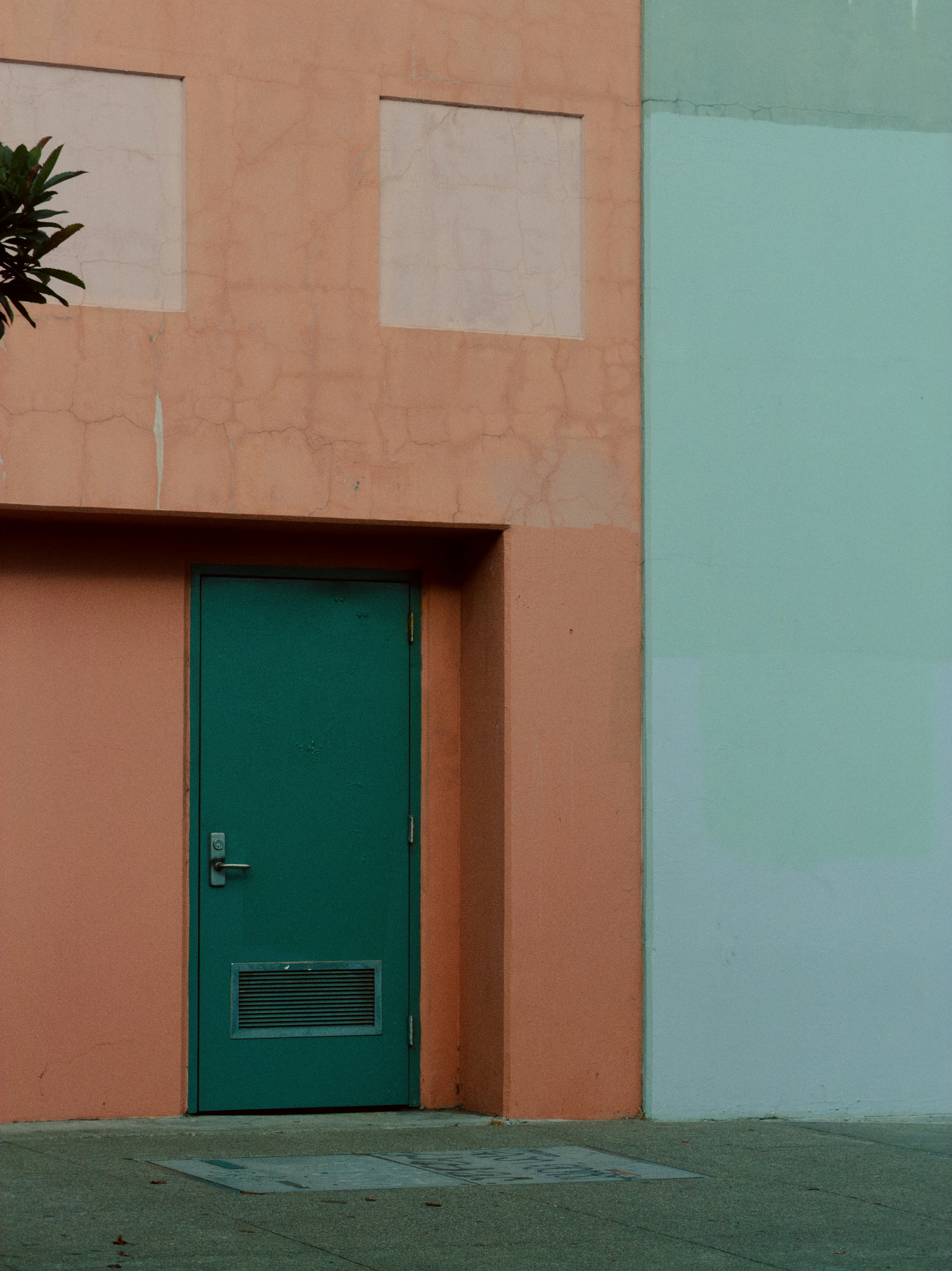 Teal Door in a Peach-Tinted Wall