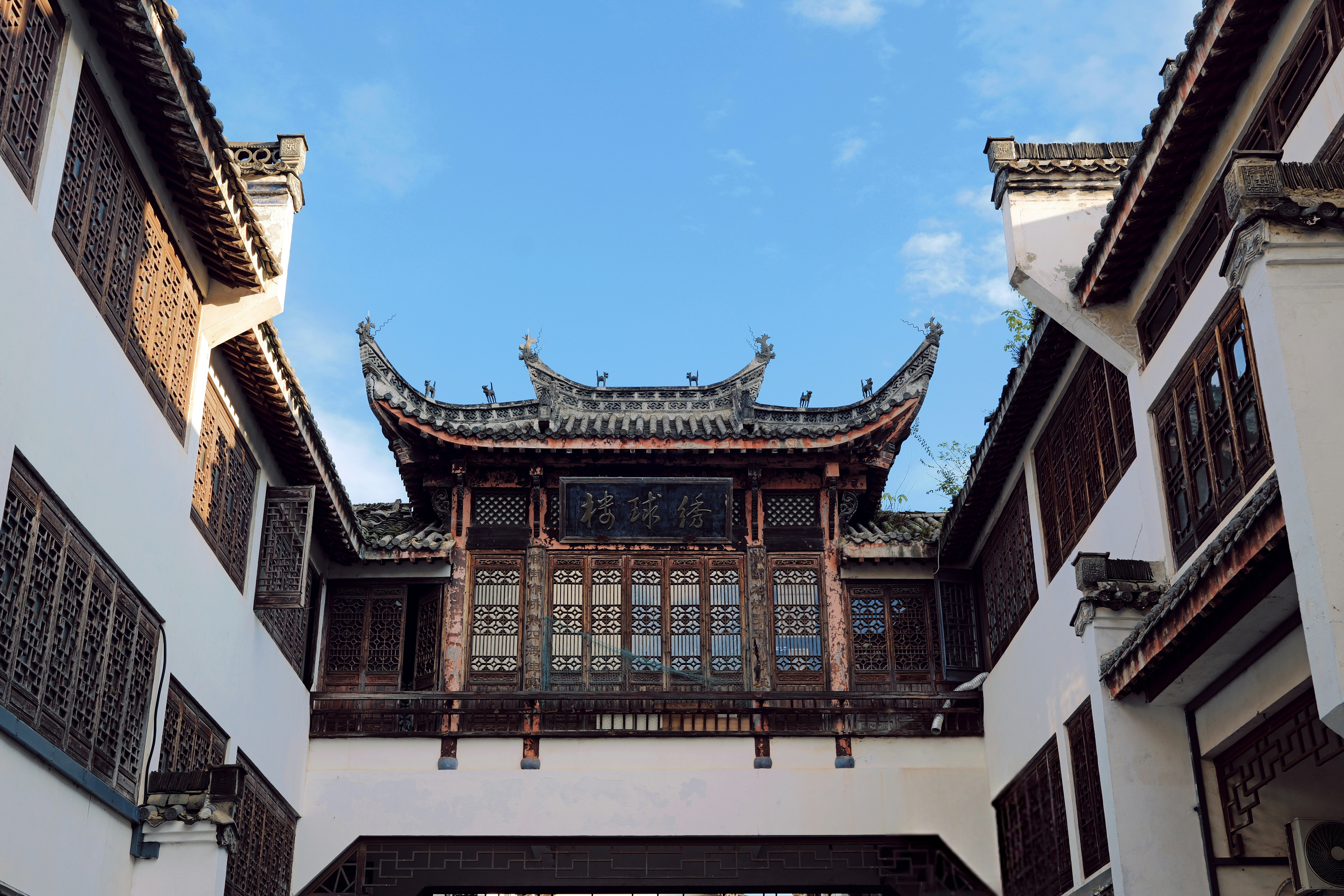 Ancient Courtyard Eaves: Central Pavilion Framed by White-Walled Galleries