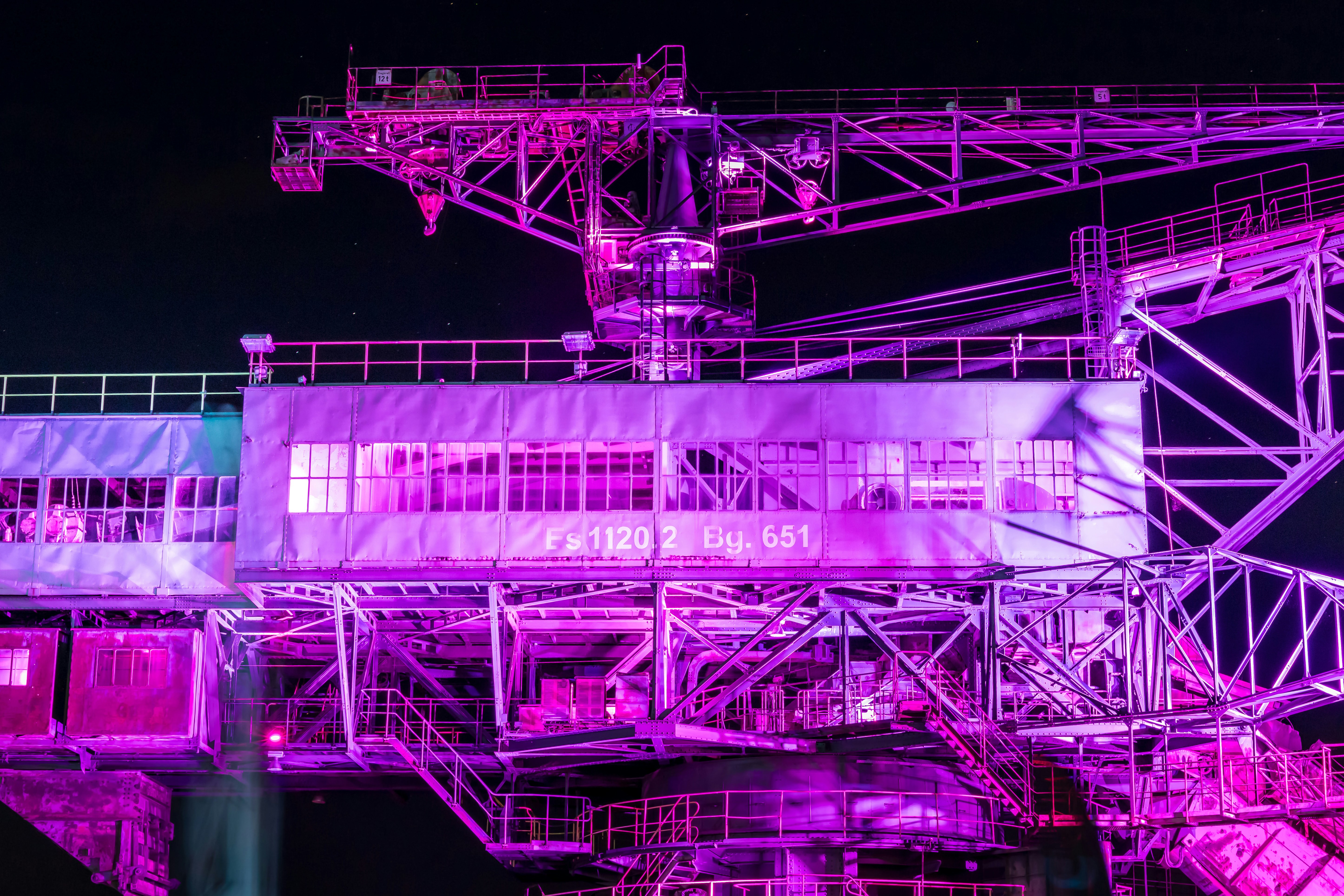 Neon-lit industrial silhouette under a purple night sky