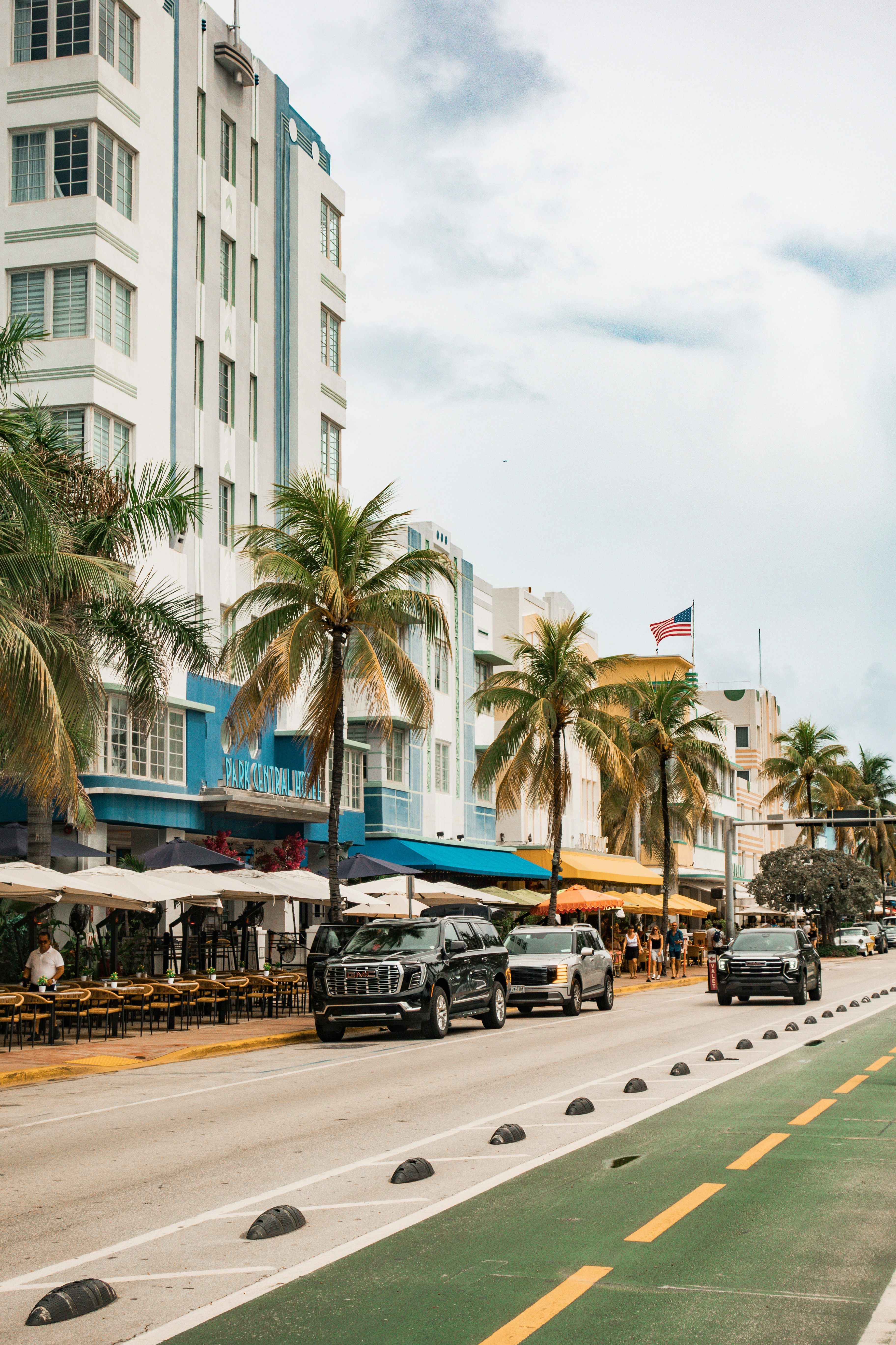 Sunlit Oceanfront Street with Palm Courtyard Cafés