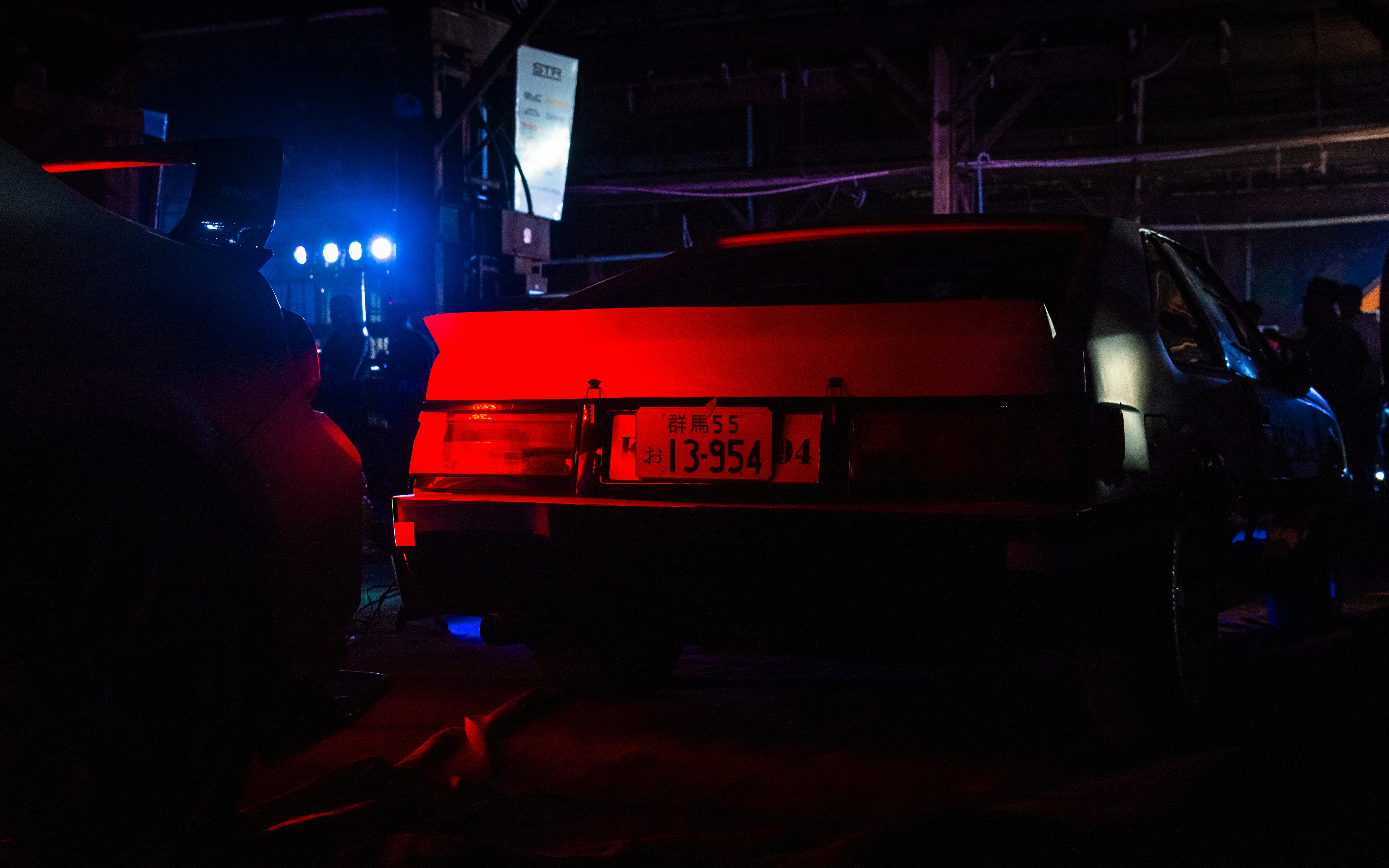 Nighttime Car Row: Red Tail Lights in a Dim Indoor Scene