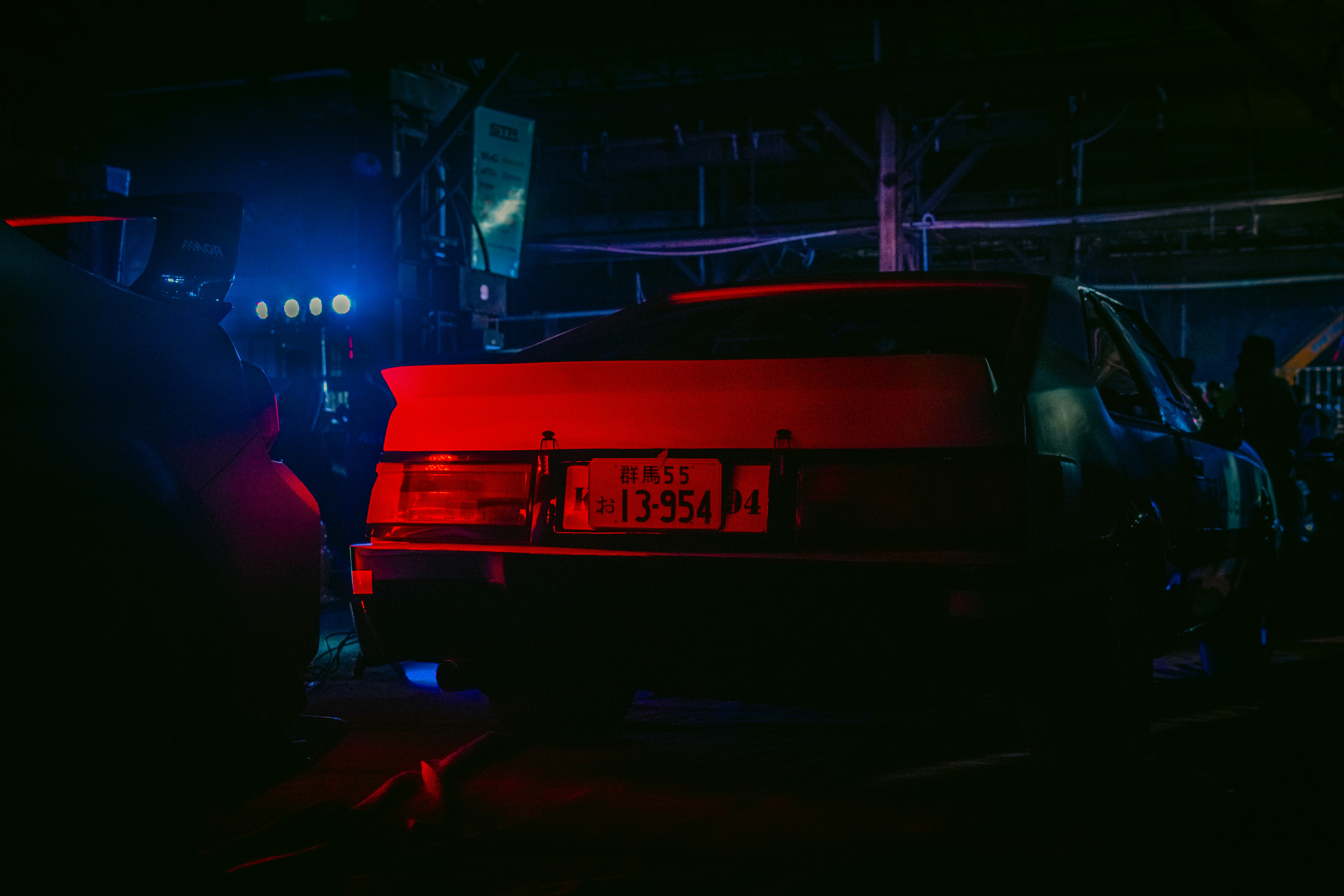 Neon-Tinted Back-Wlot: A Dusk-Blue Car in a Dim Dock Scene