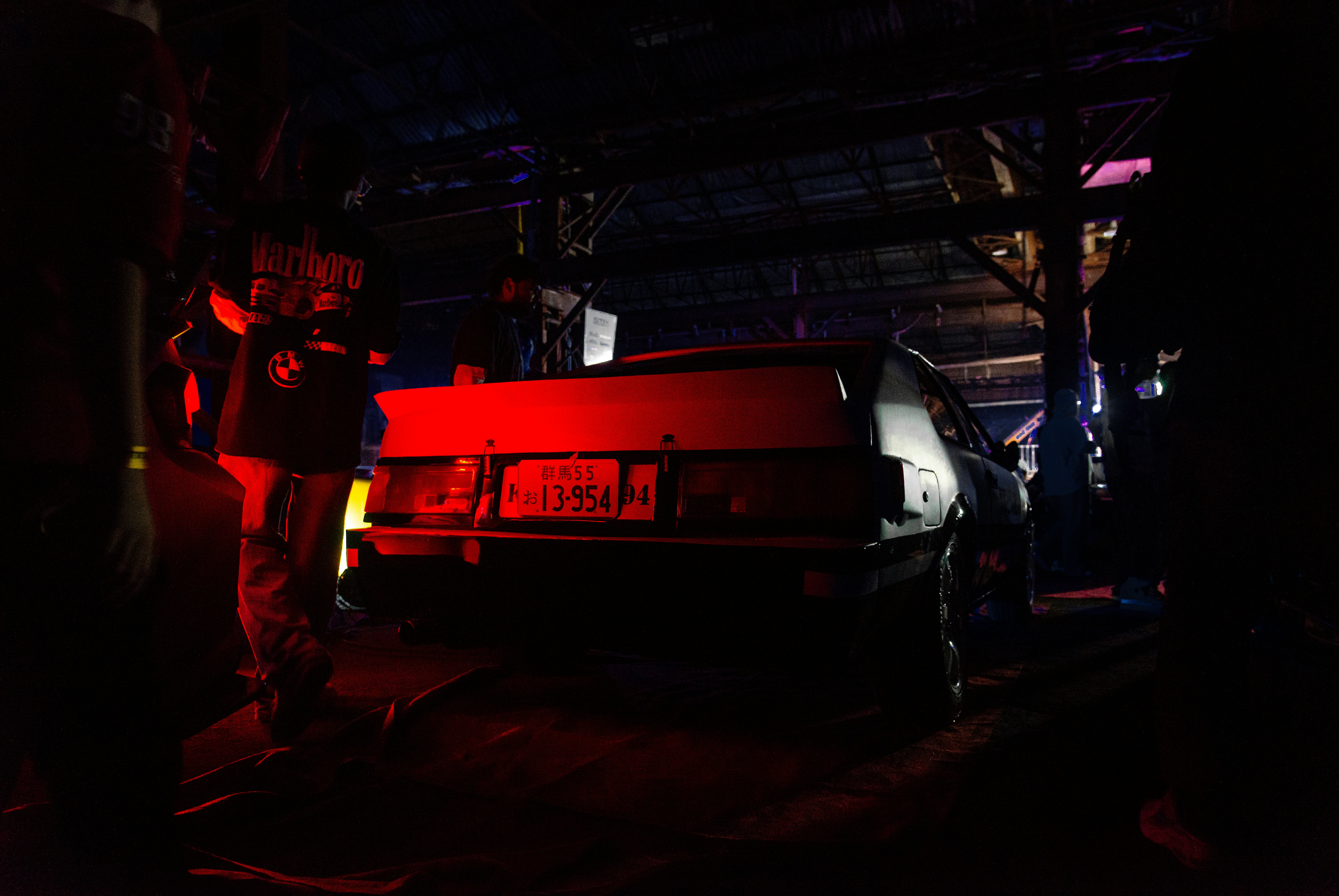 Red Neon Echo: A Car Amid The Night Club Rave