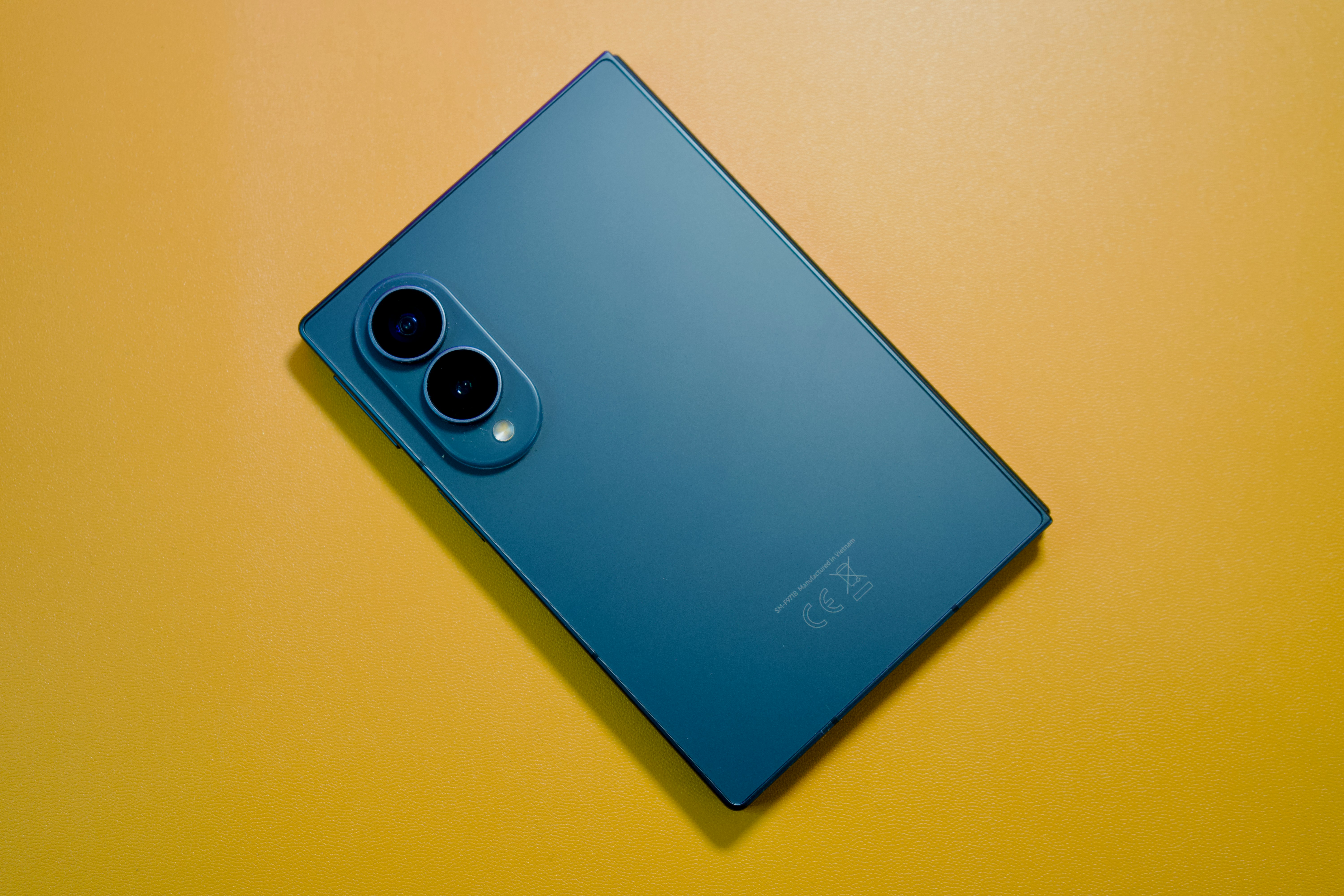 Blue Pixel Crown: A Flat-Lay of a Modern Smartphone on Yellow