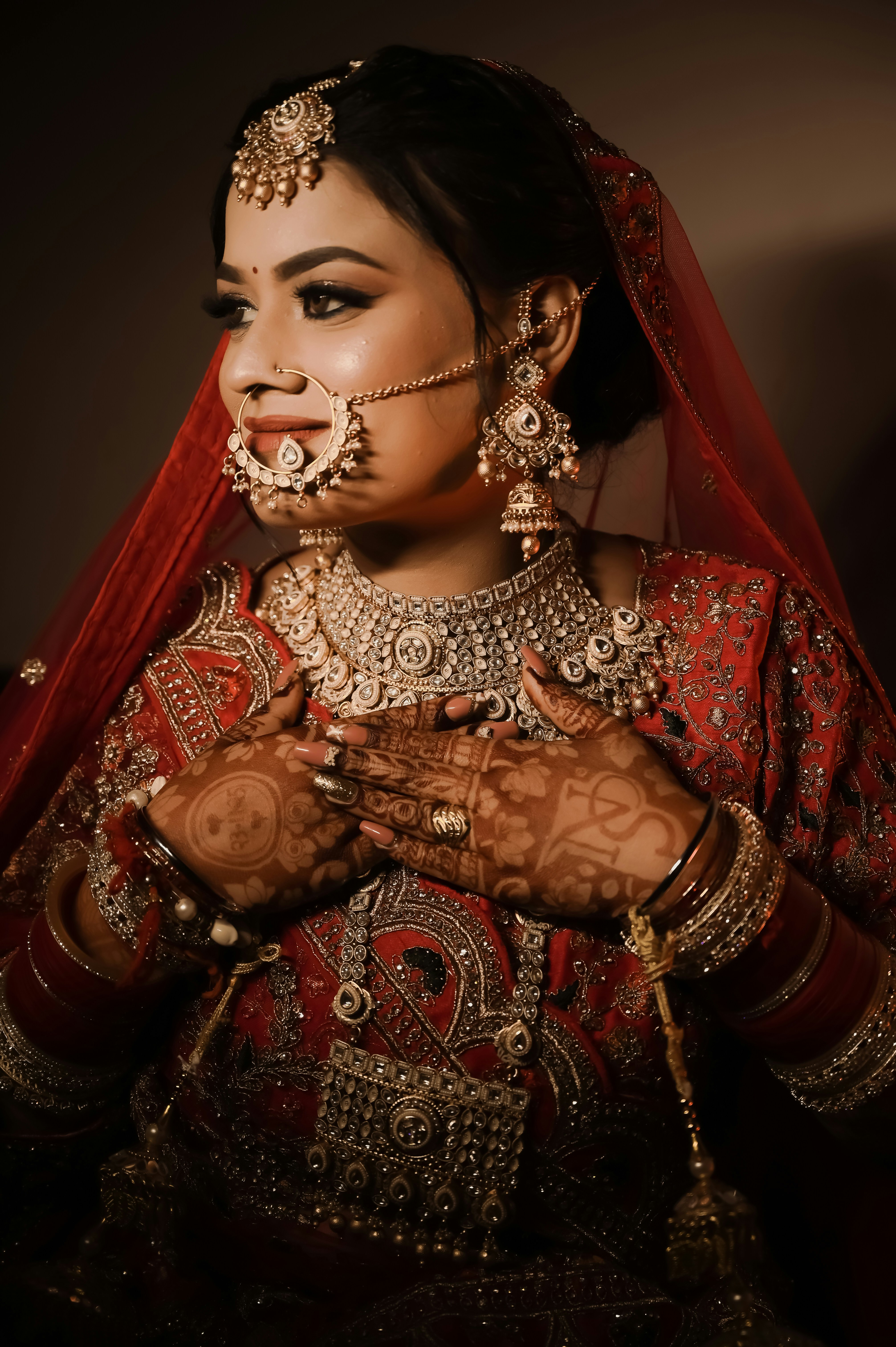 Regal bridal mahurat: a woman adorned in ornate jewelry and red sáari