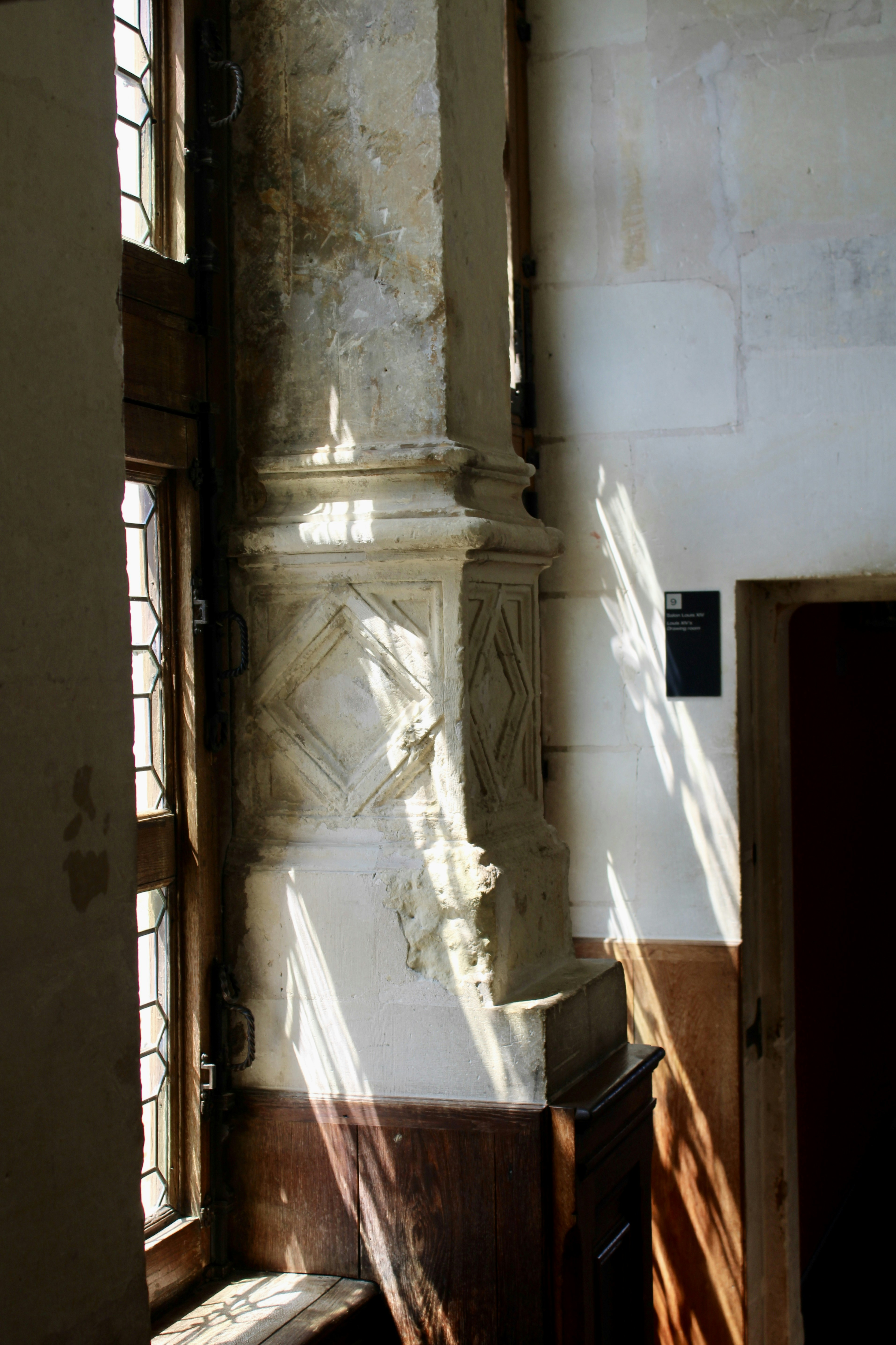 Sunlit stone column in a historic doorway hall