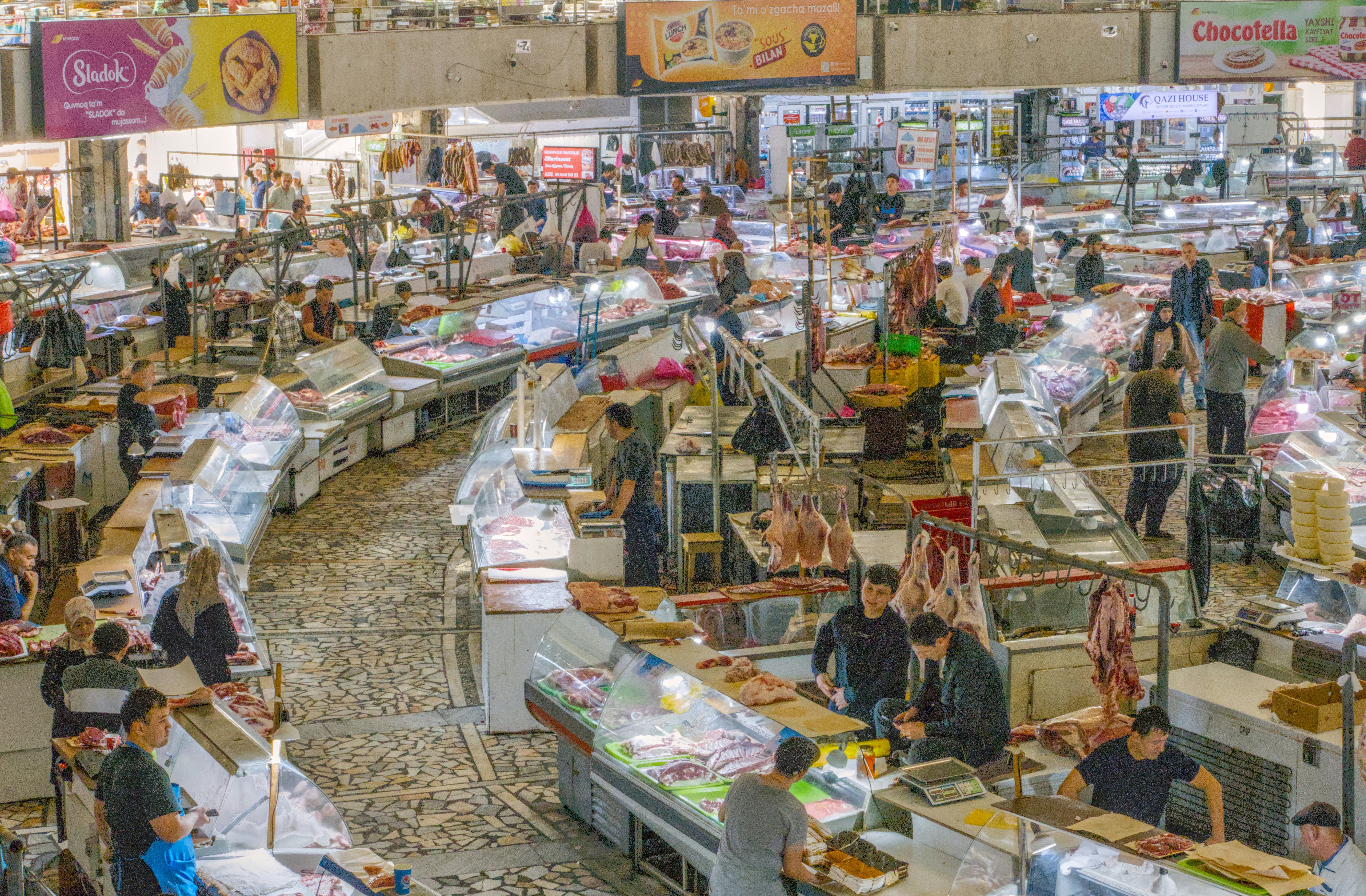 Bustling Fish and Meat Market Aisle: Bright Counters Under Neon Signs