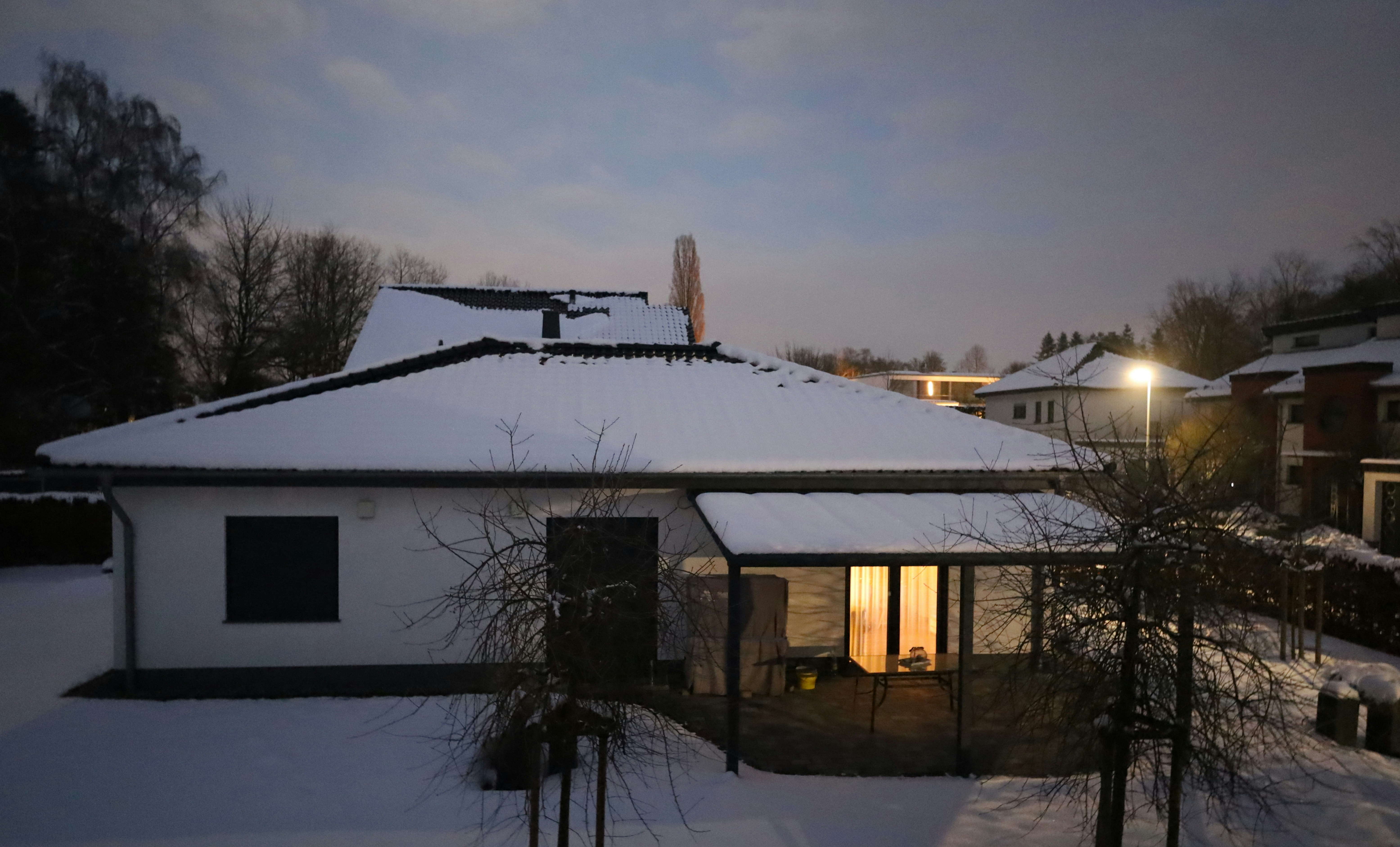 Snowlit House with Warm Porch Glow at Twilight