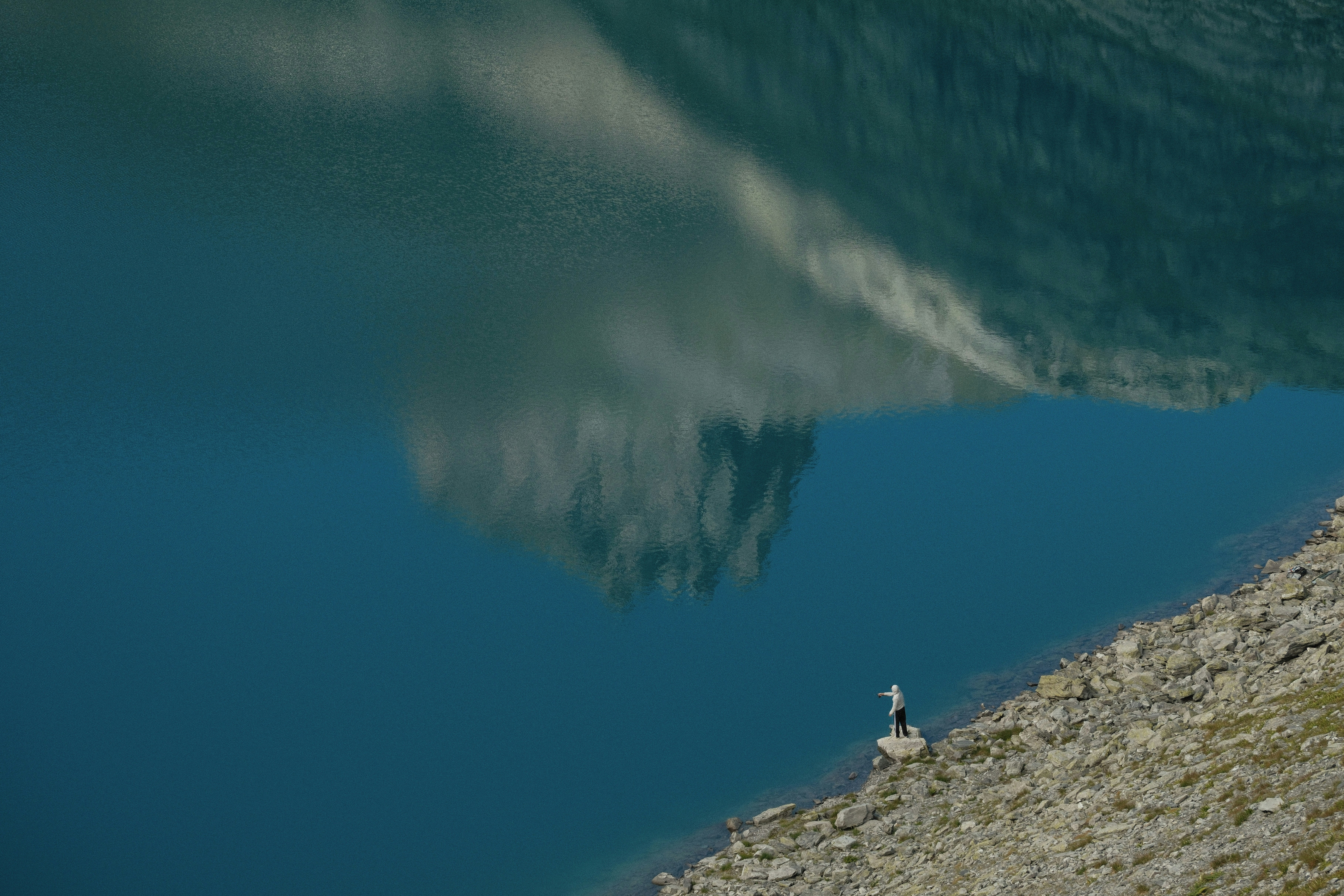 Wanderer on the Rim: A Lone Figure Between Sky and Mirror Lake