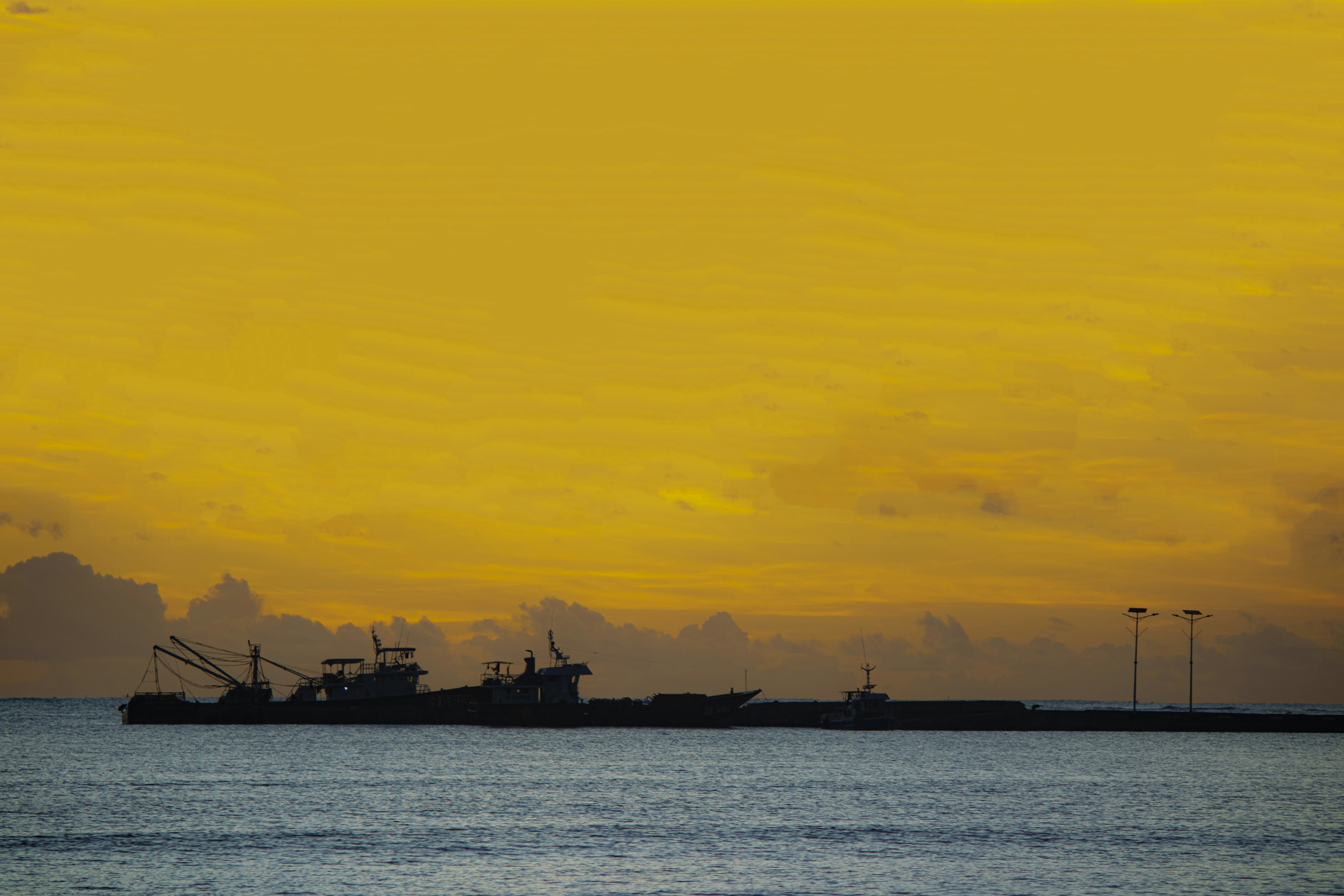 Harbor Silhouette at Dusk: Boats Beneath a Burnt Sky