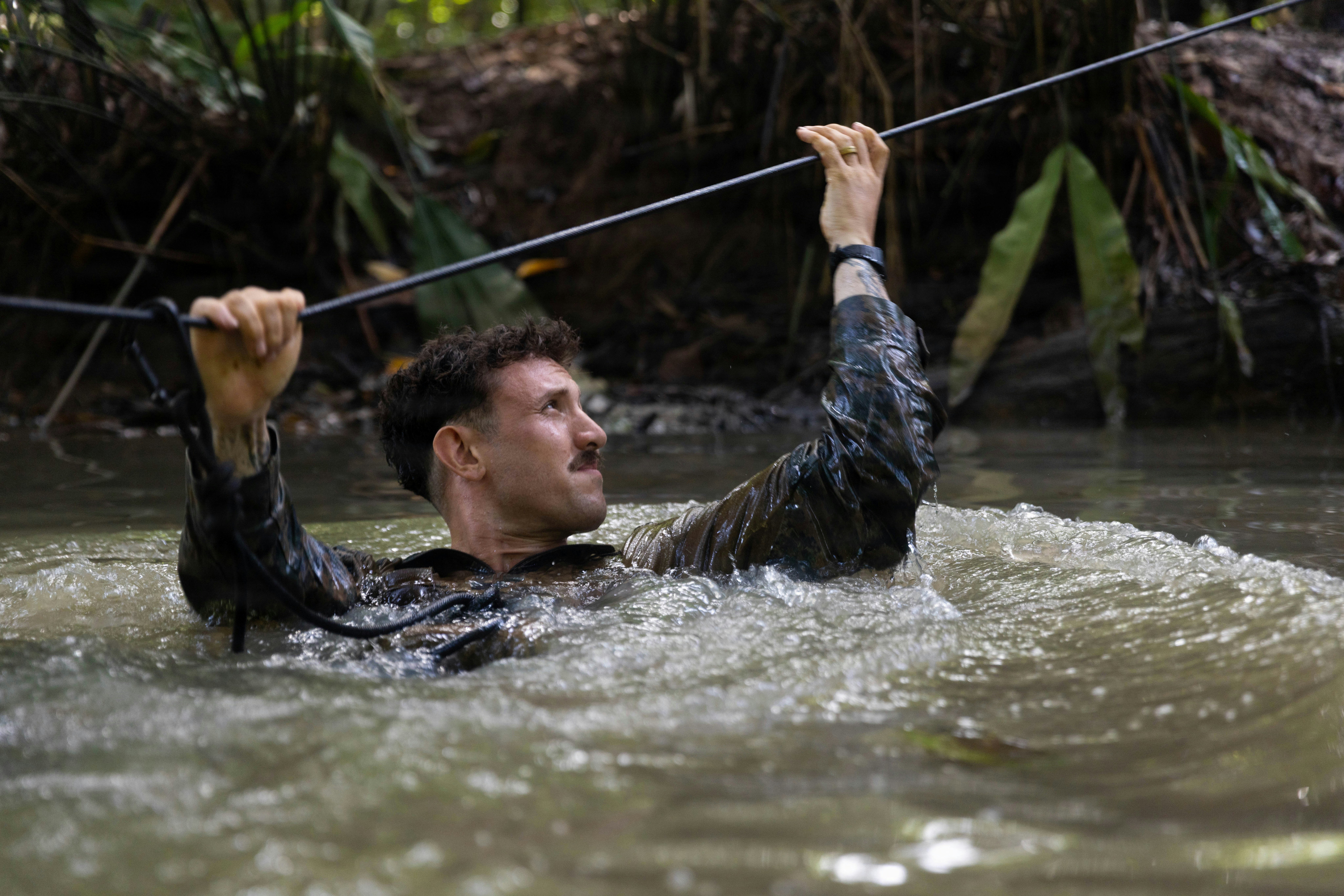 Midair Tug: A Man Reaching for Stability in Swift River Currents