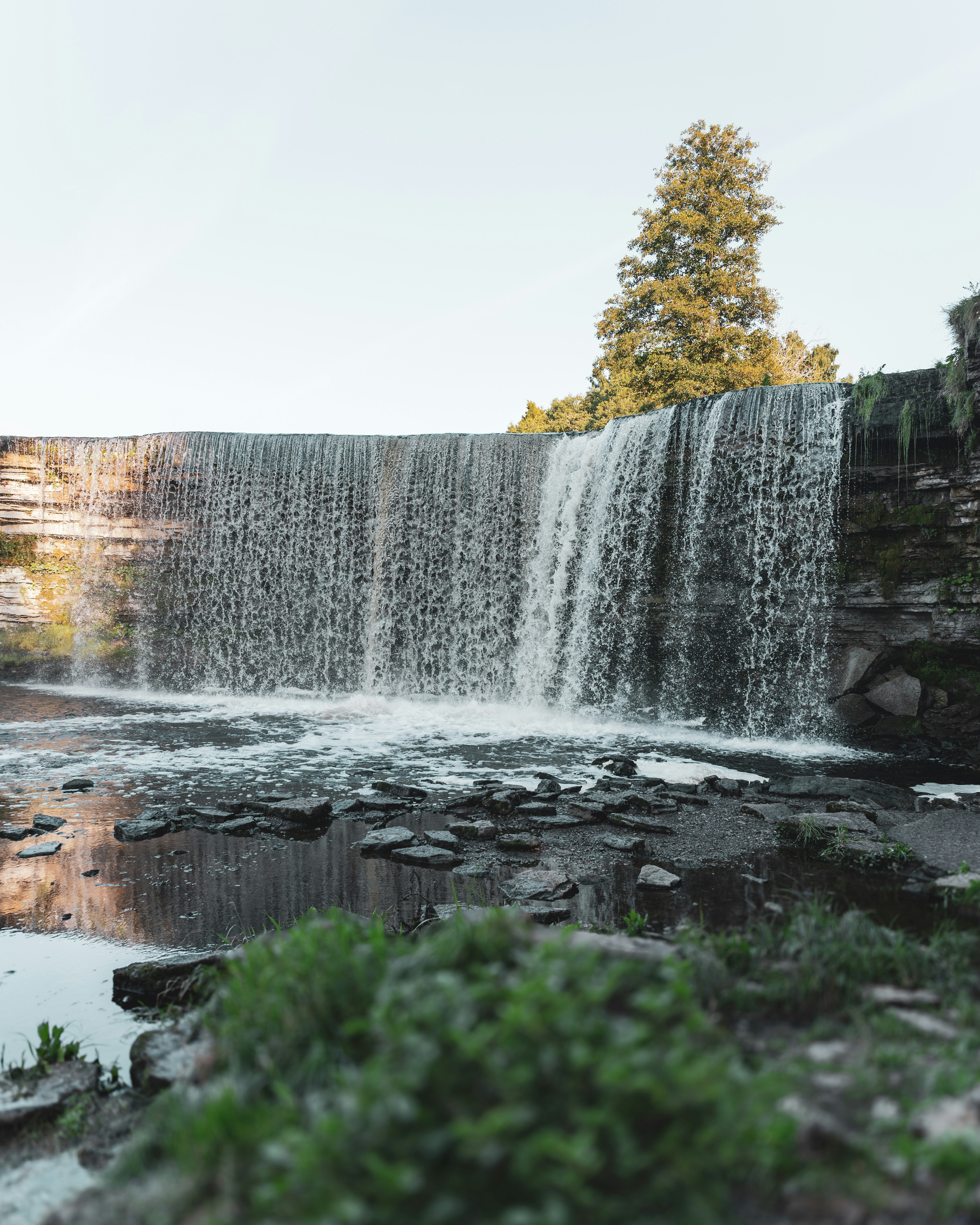 Cascade at Dusk: A Quiet Riverfall Framed by Foliage