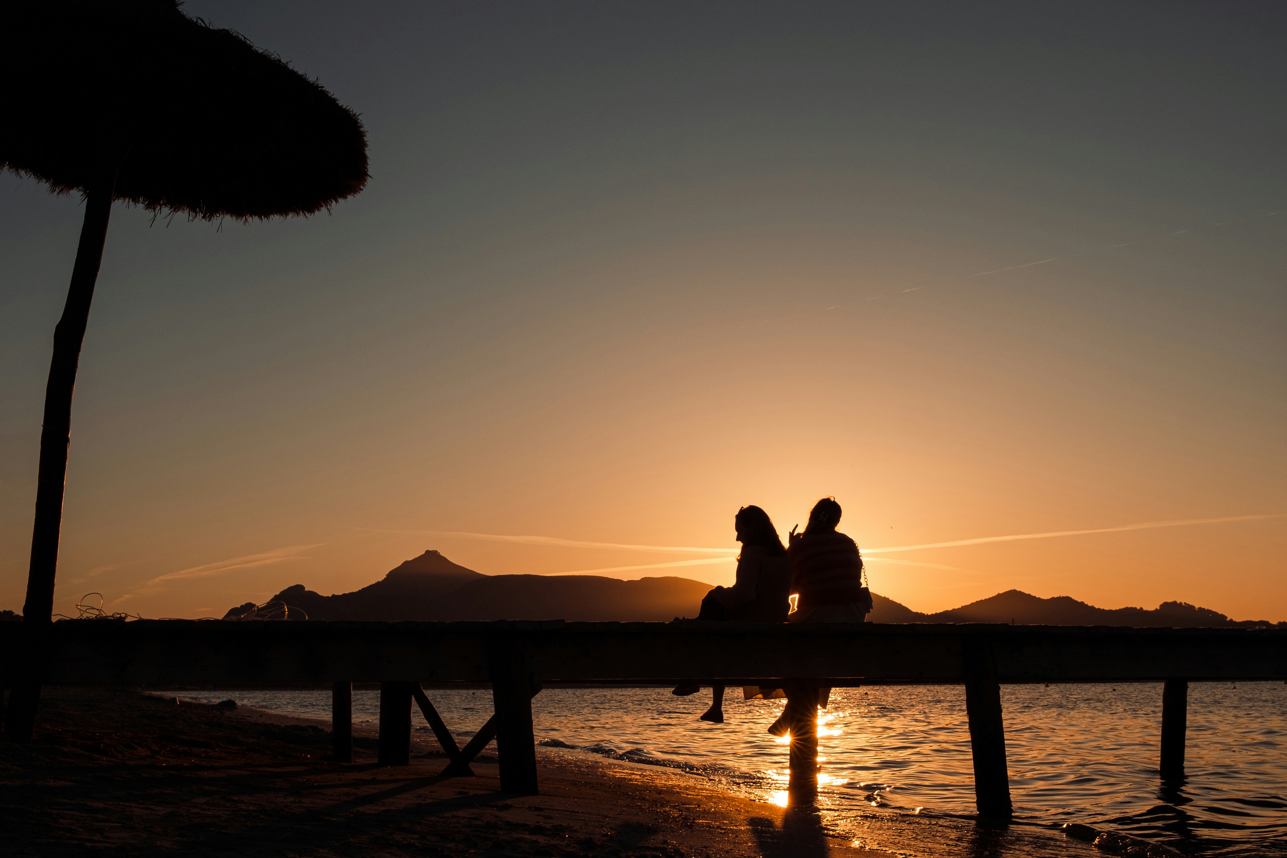 Silhouetted Friends on a Dusk Pier