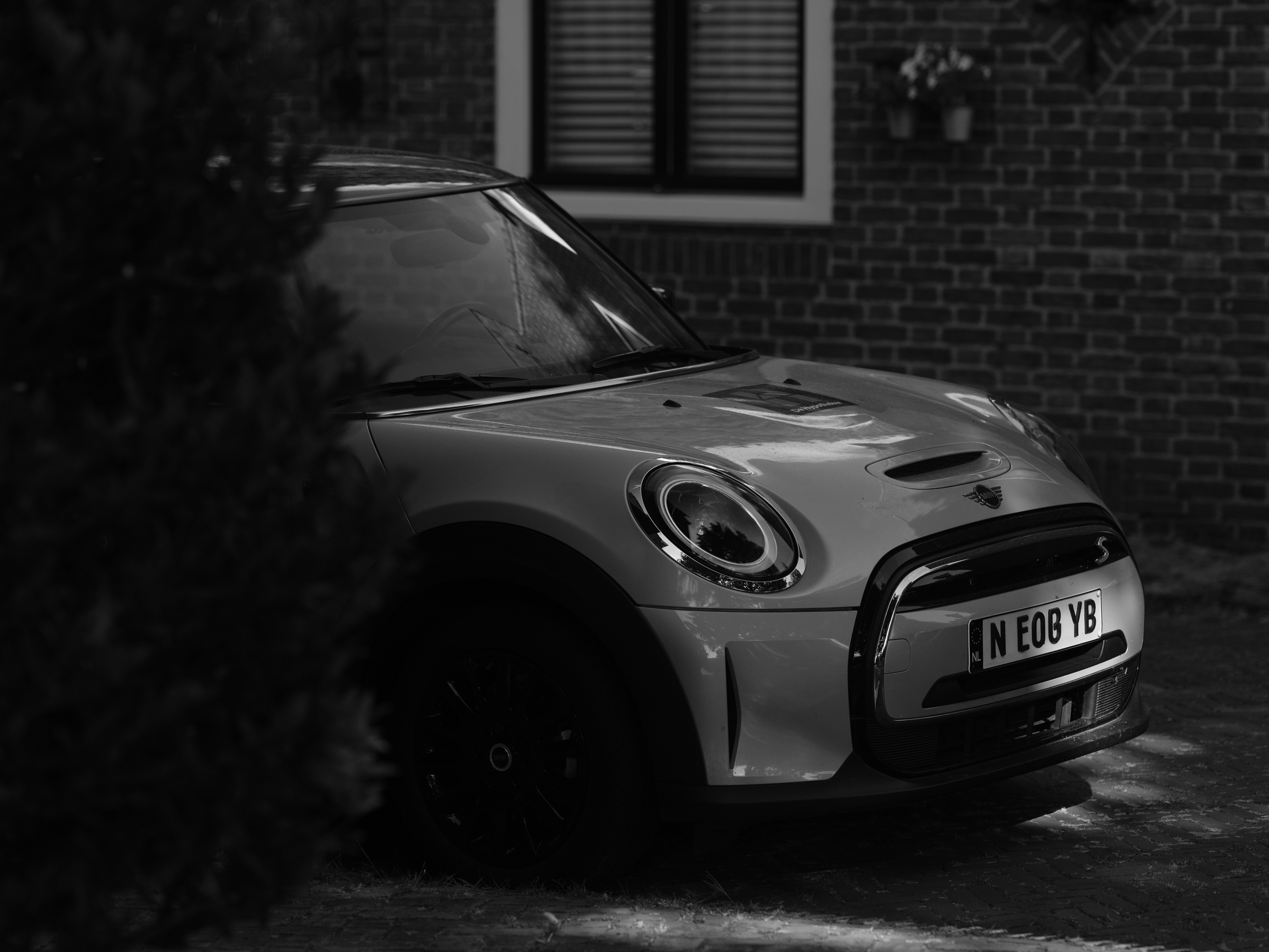 Midnight Mini: A Mini Cooper Resting in Shadowed Brick Facade