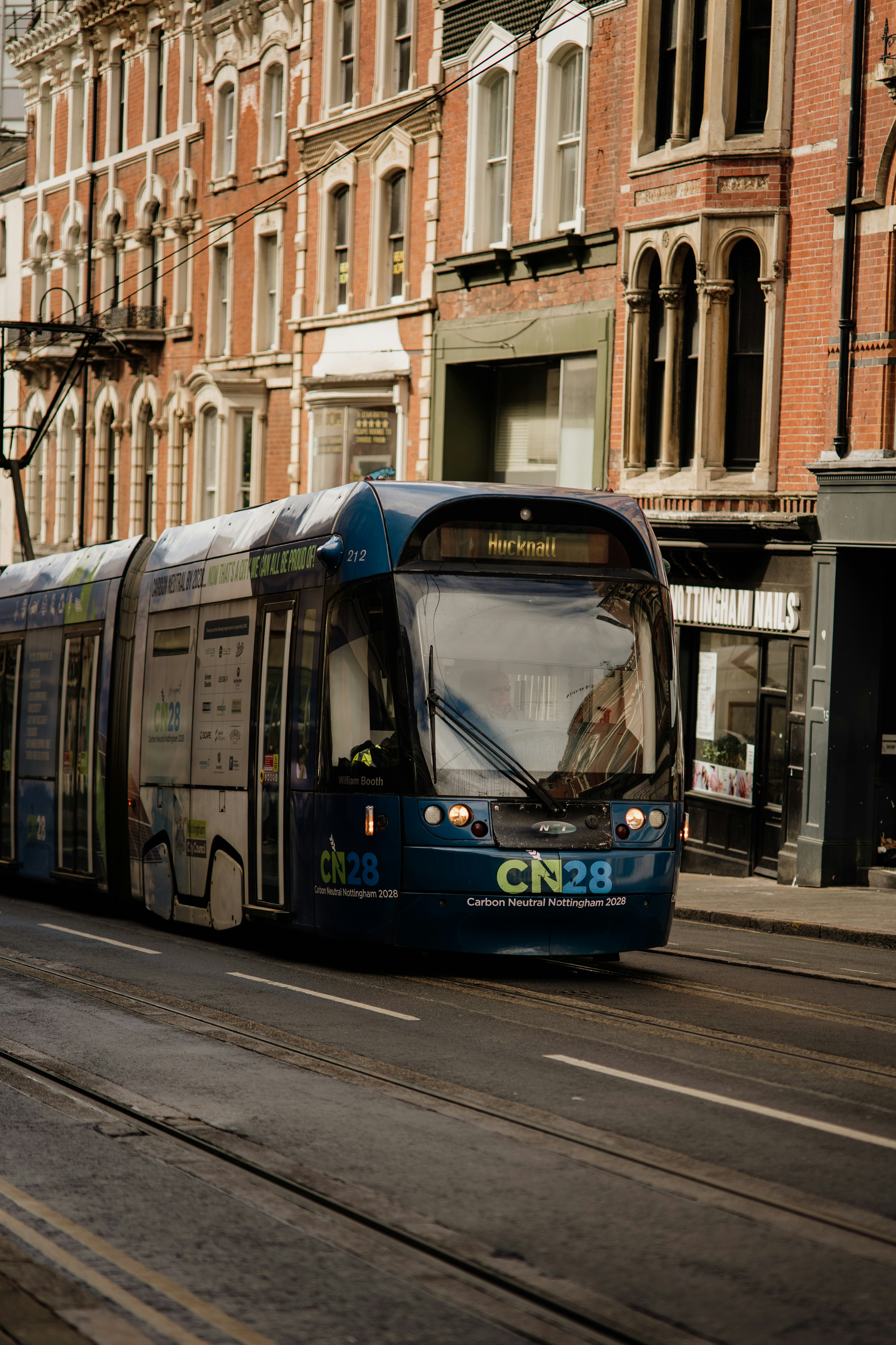 Blue Tram Rushing Through a Historic Street