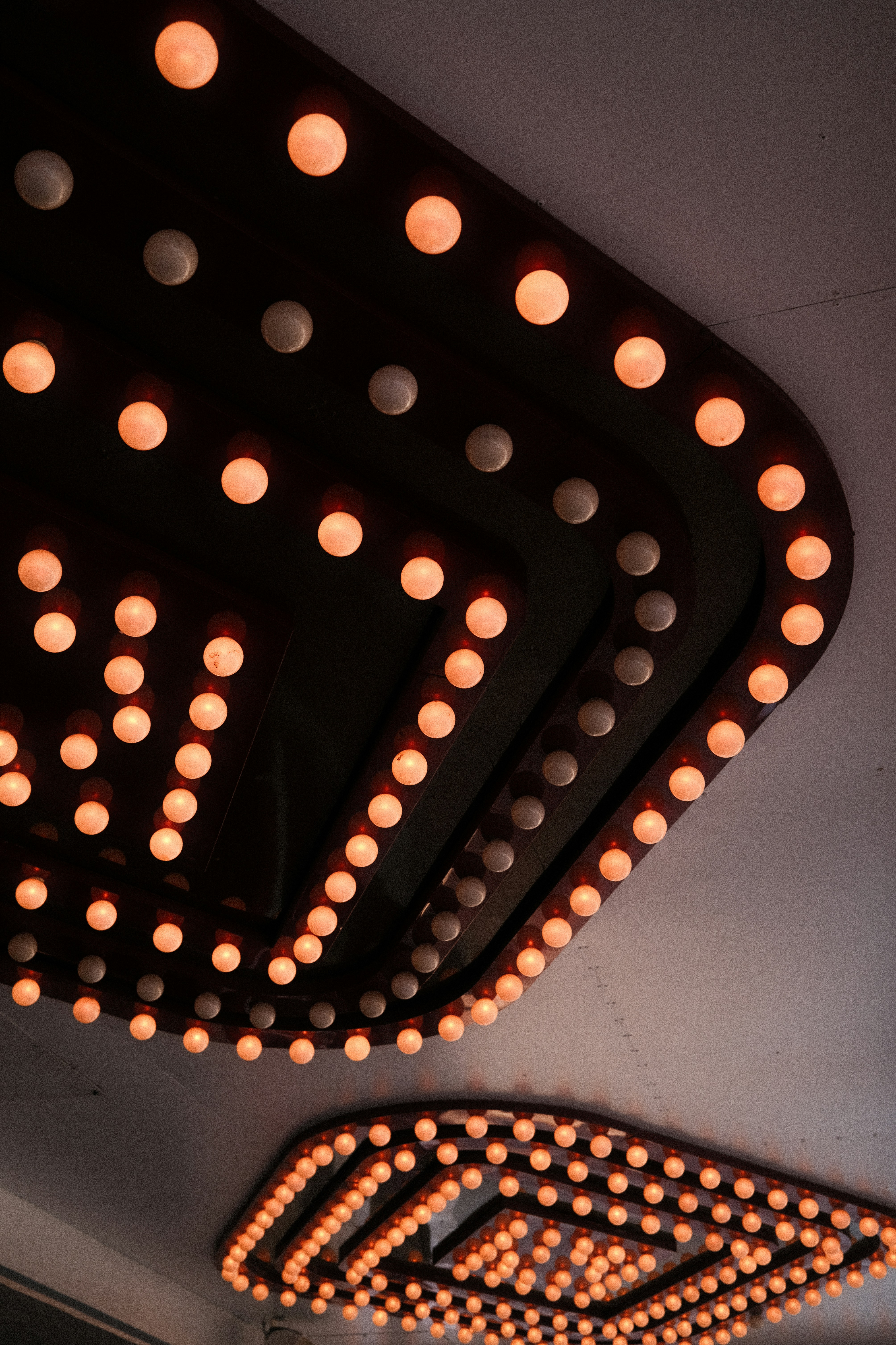 Neon Grid of Orbs: A Spiral of Lights in a Retro Theater Ceiling