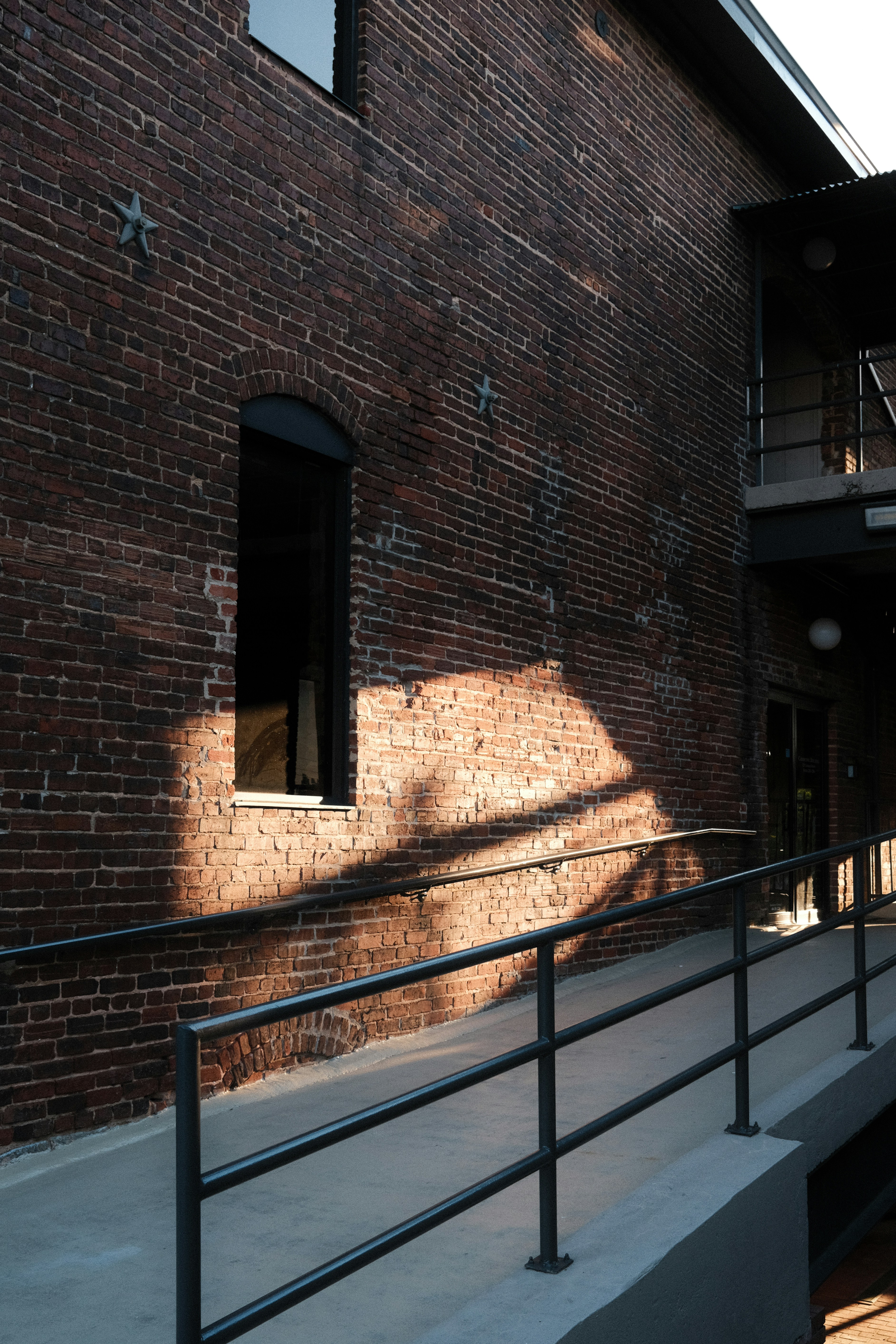 Brick Wall Echoes: Sunlit Window and Shadow Arc