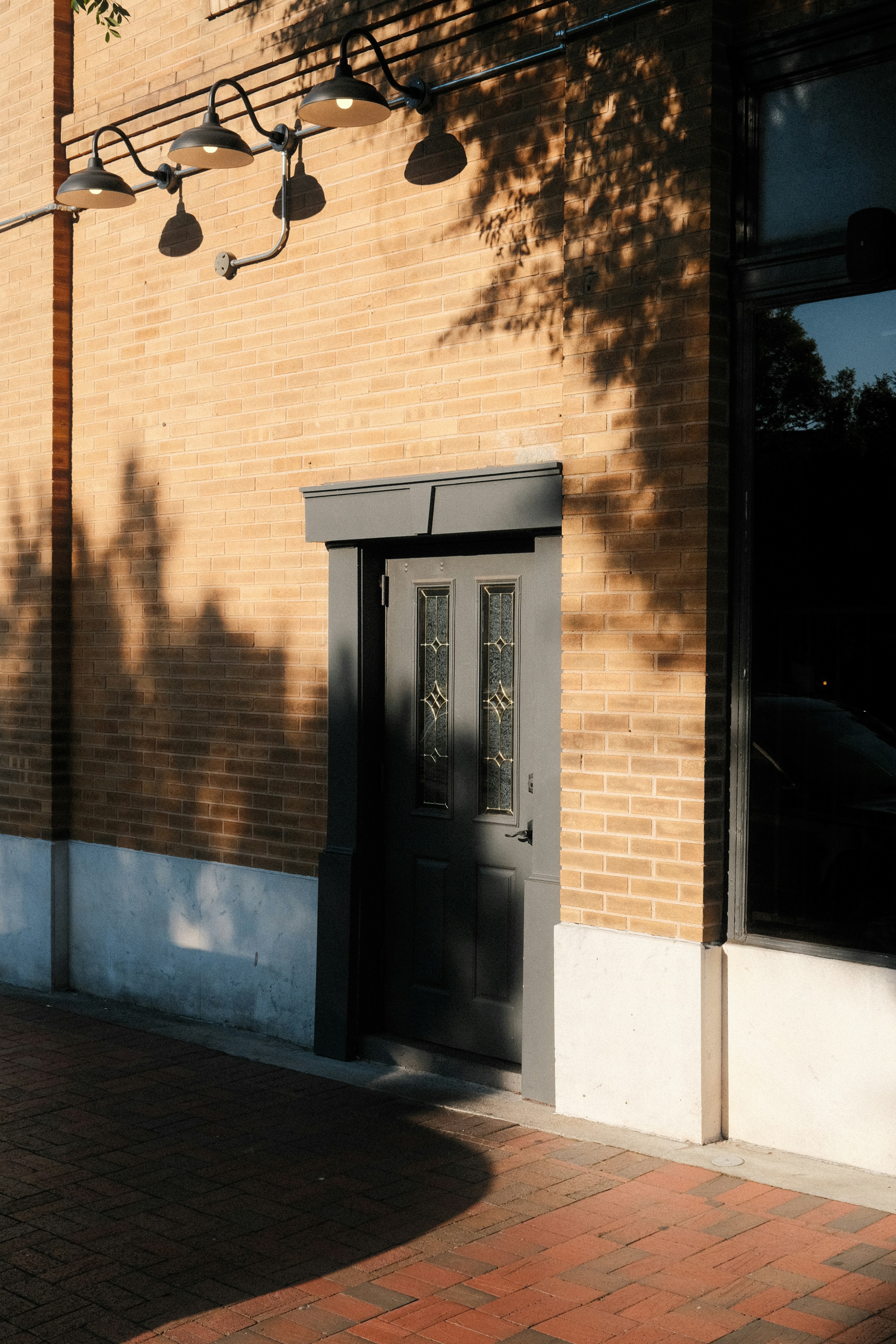 Sunlit Brick Facade and Doorway Casting a Quiet Shadow