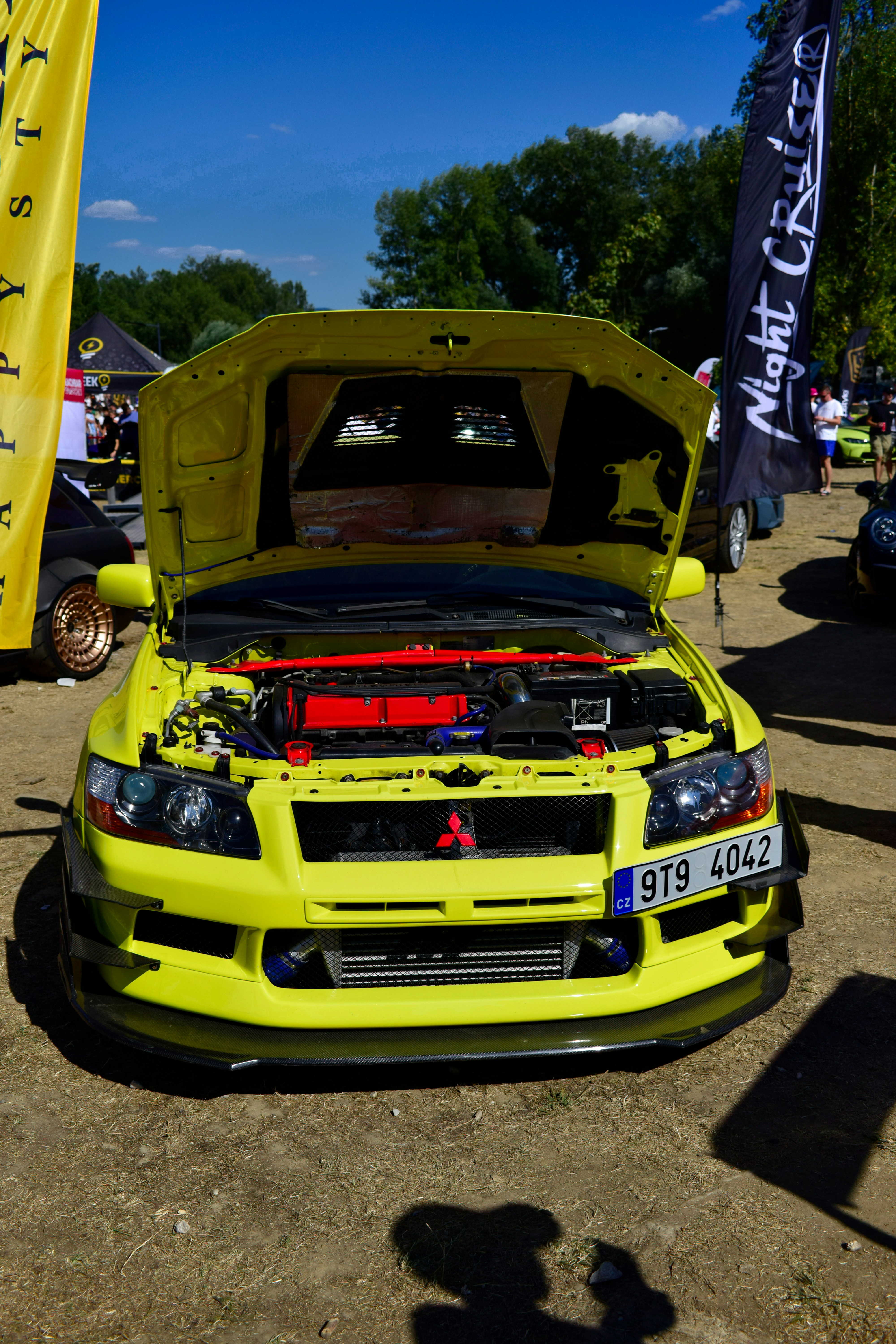 Lime Lightning under the Hood: a bright Mitsubishi at a sunny car show