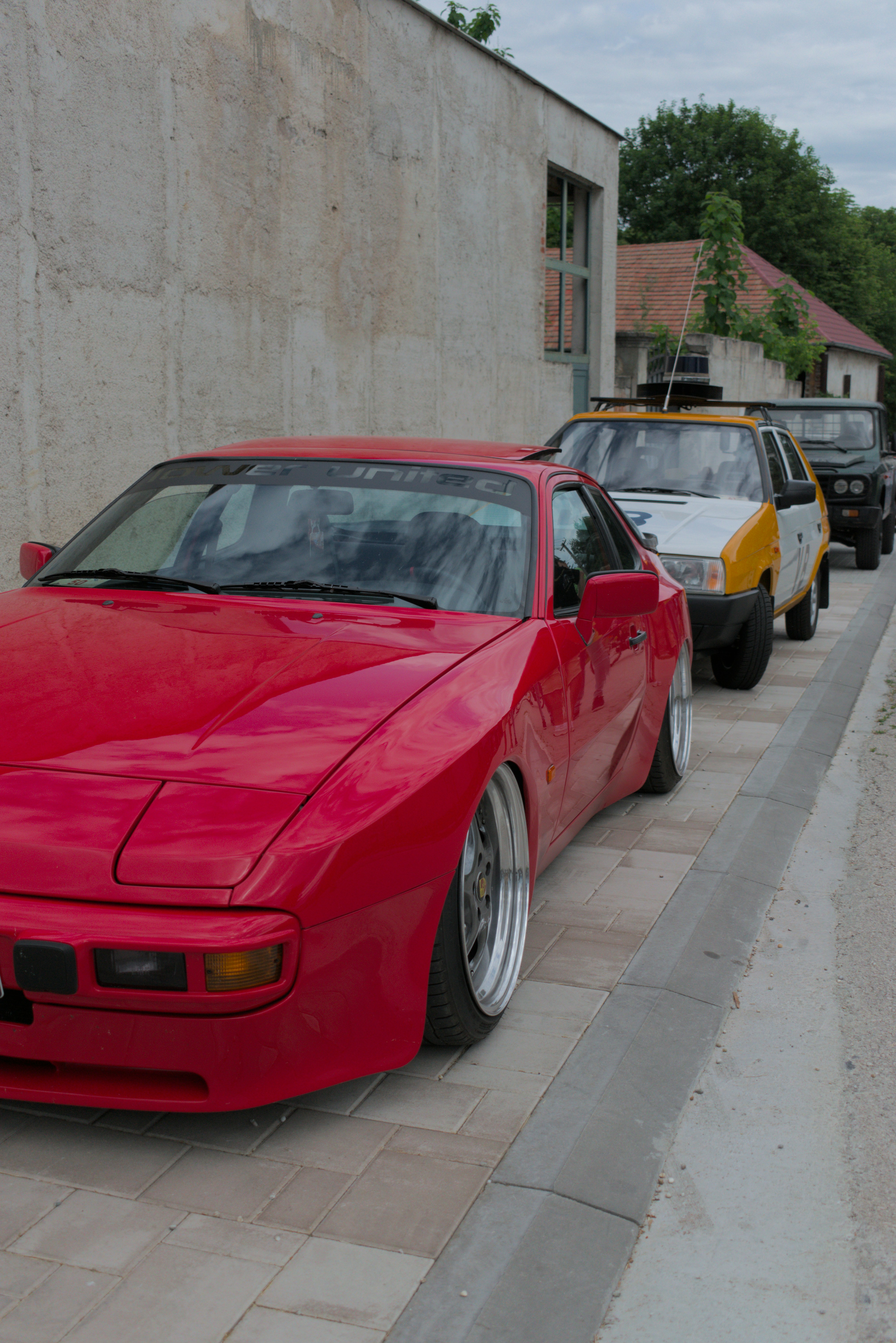 Red Roadster Parade: A Line of Cars in a Quiet Street
