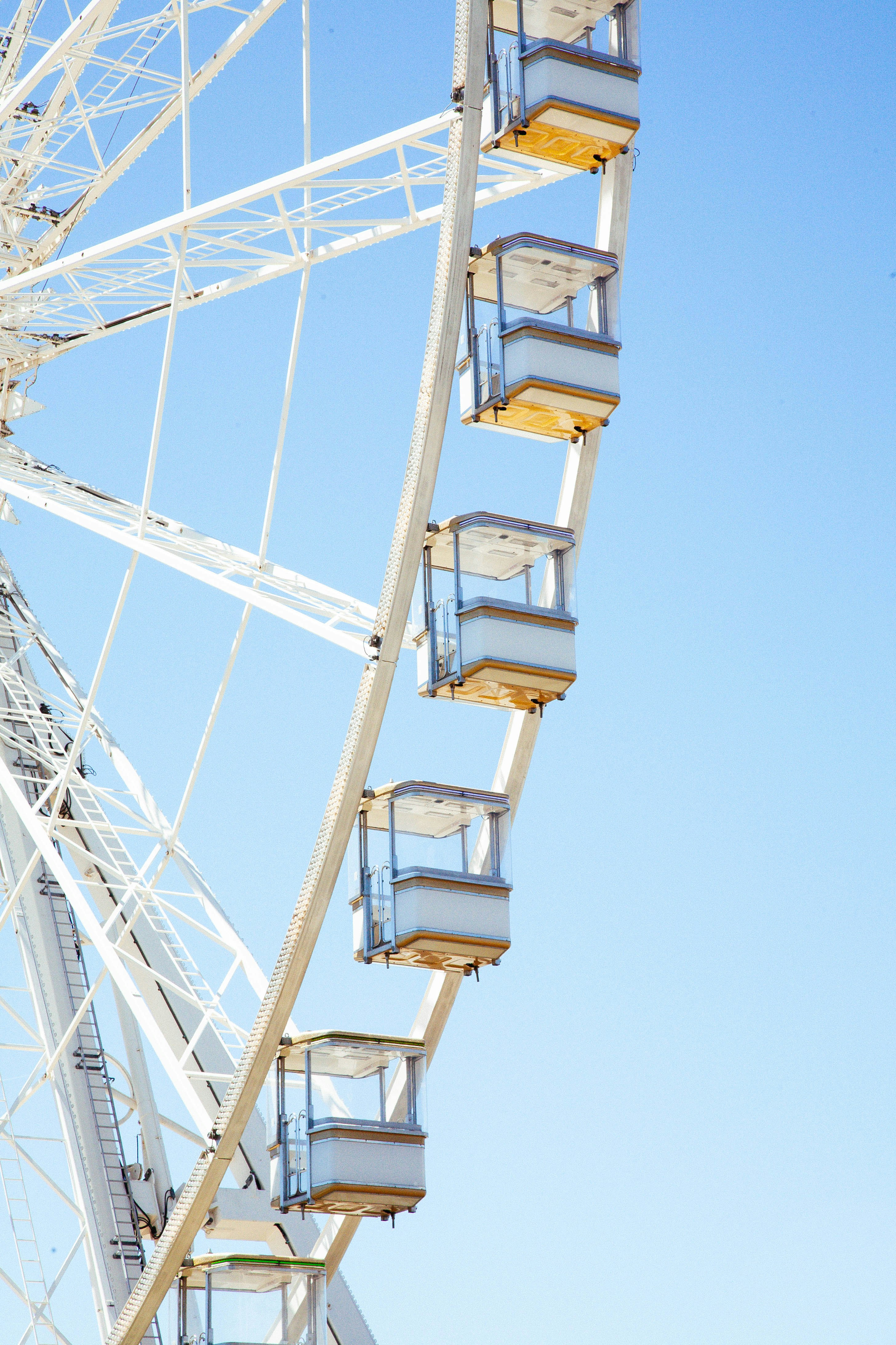 Blue Sky, White Wheels: A Ferris Wheel Frame Reaching Toward Summer