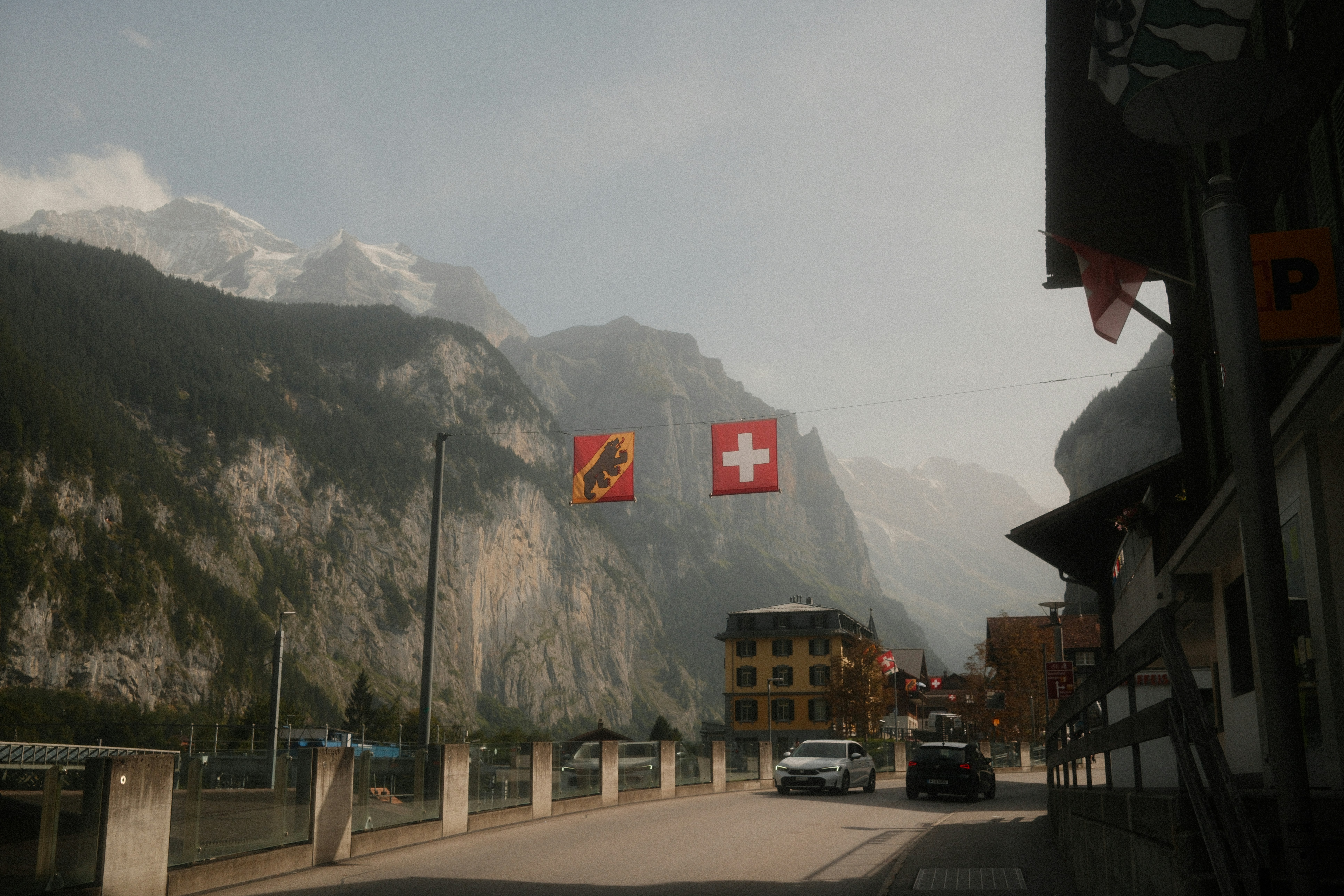 Swiss Alpine Boulevard: Flags, Road, and Mountain Backdrop
