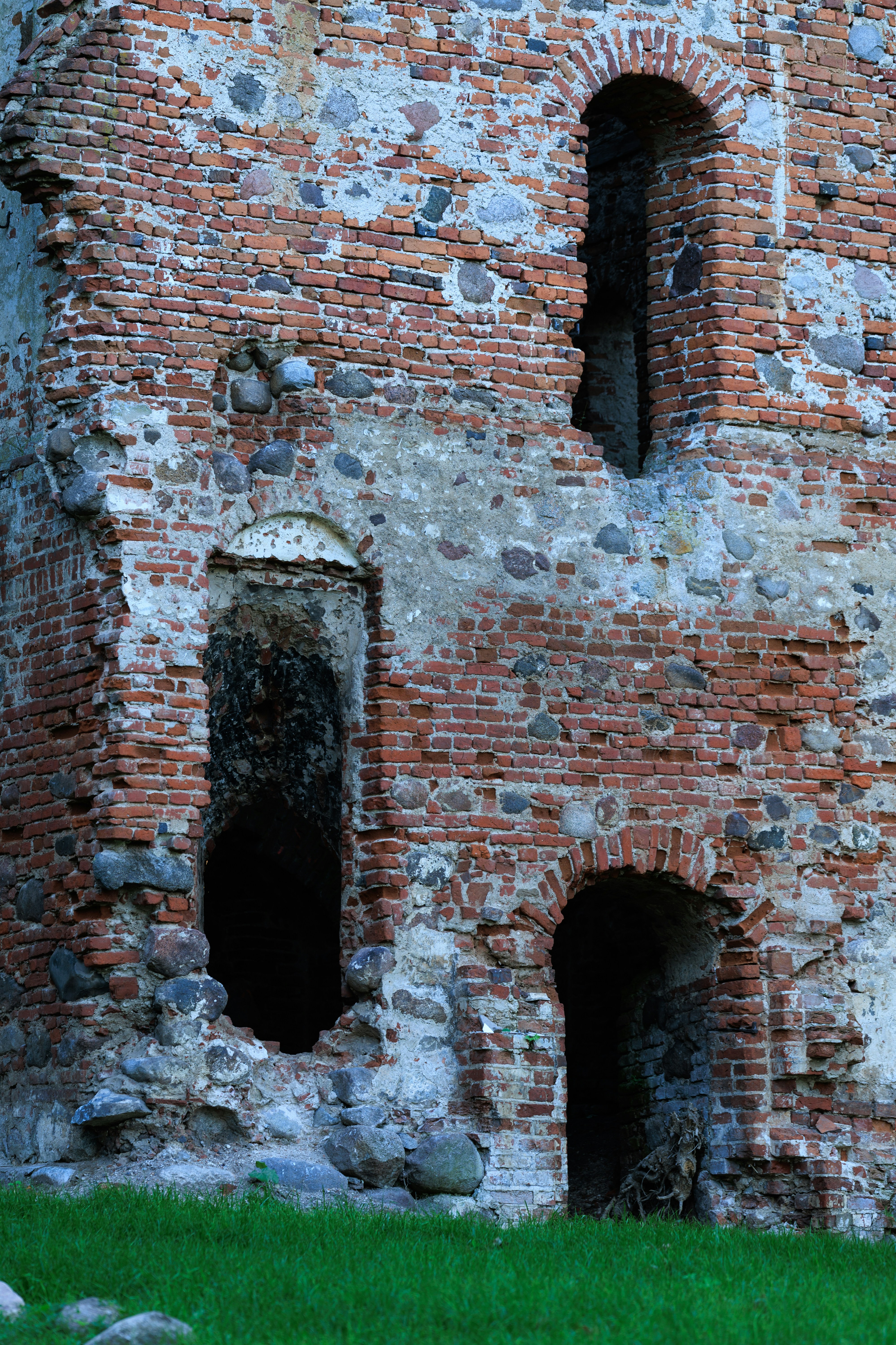Weathered Brick Ramparts: A Ruined Structure Amid Green Keep