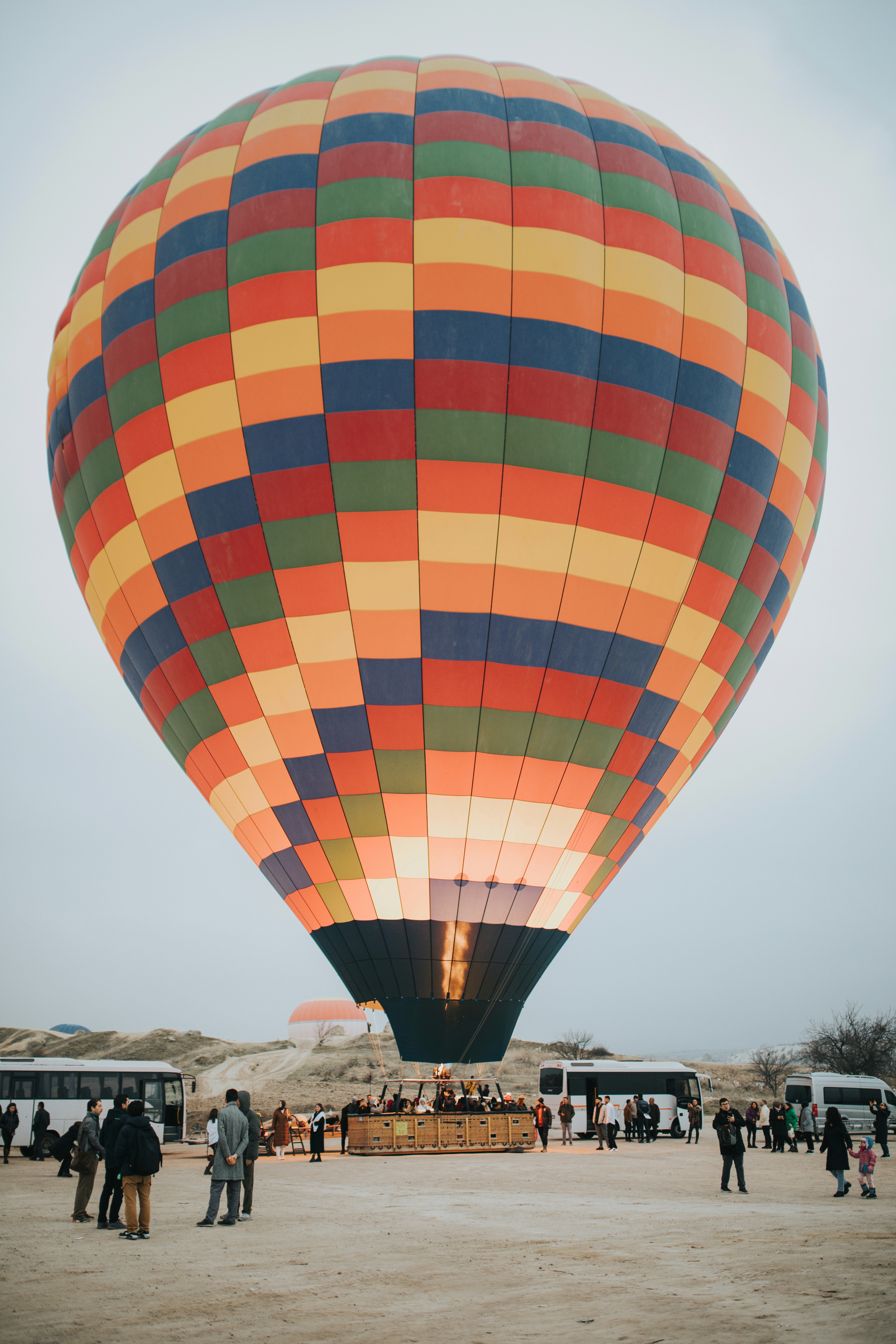 Colorful Umbilical Lift: A Balloon Rising Over the Desert Crowd