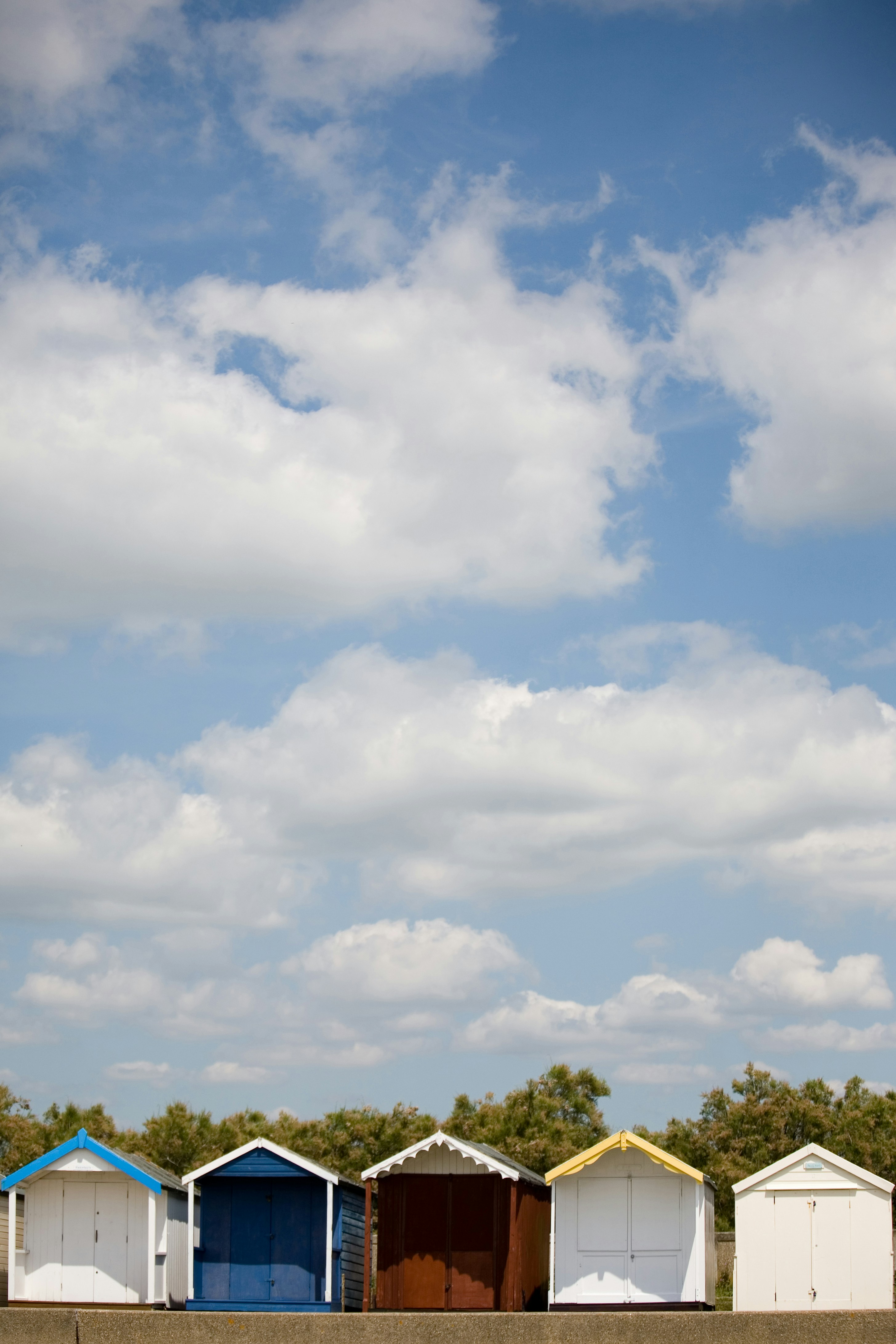 Row of Beach Cabins Under a Sky Full of Clouds