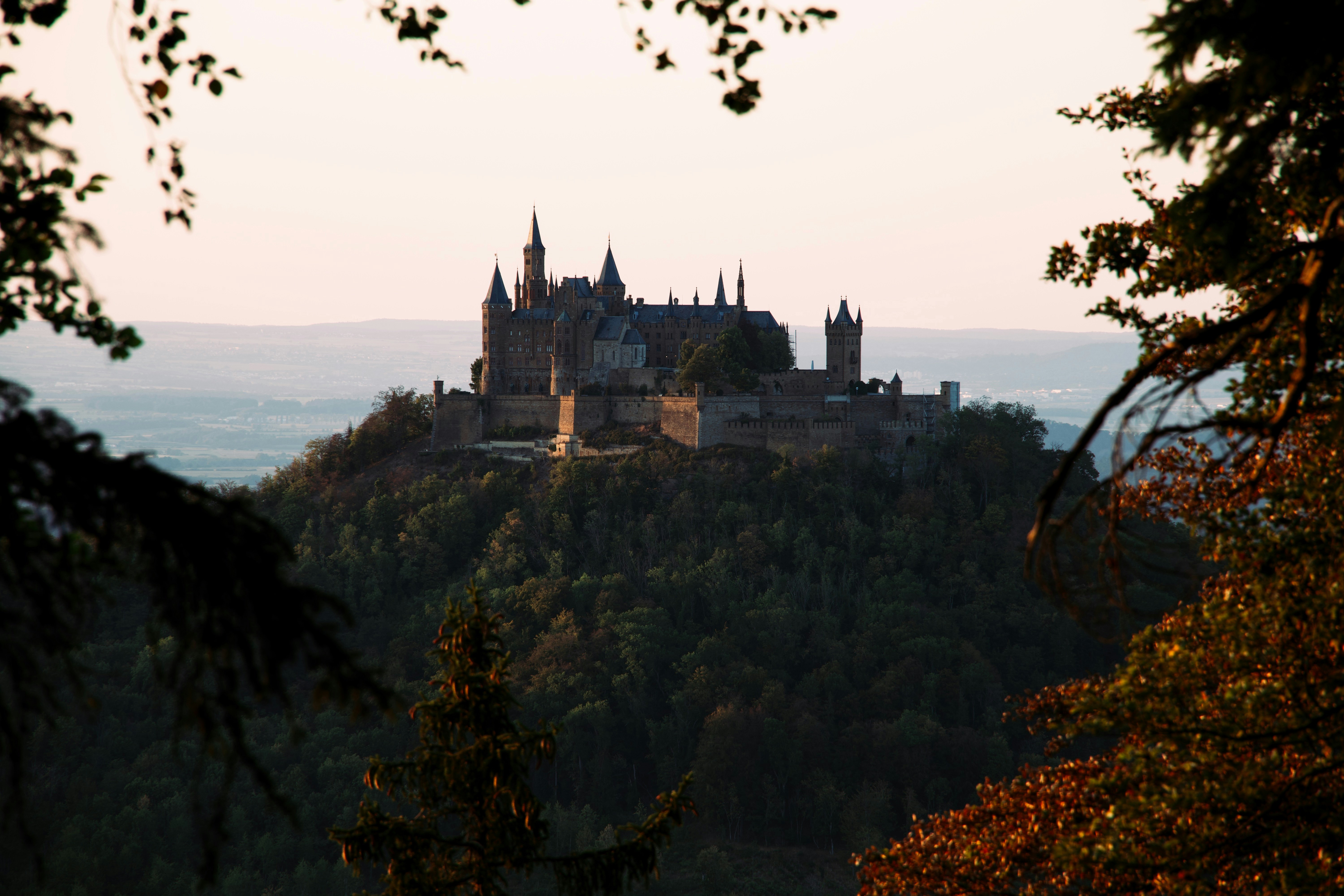 Castle on a Hill: A Sunset Silhouette over the Forested Ridge