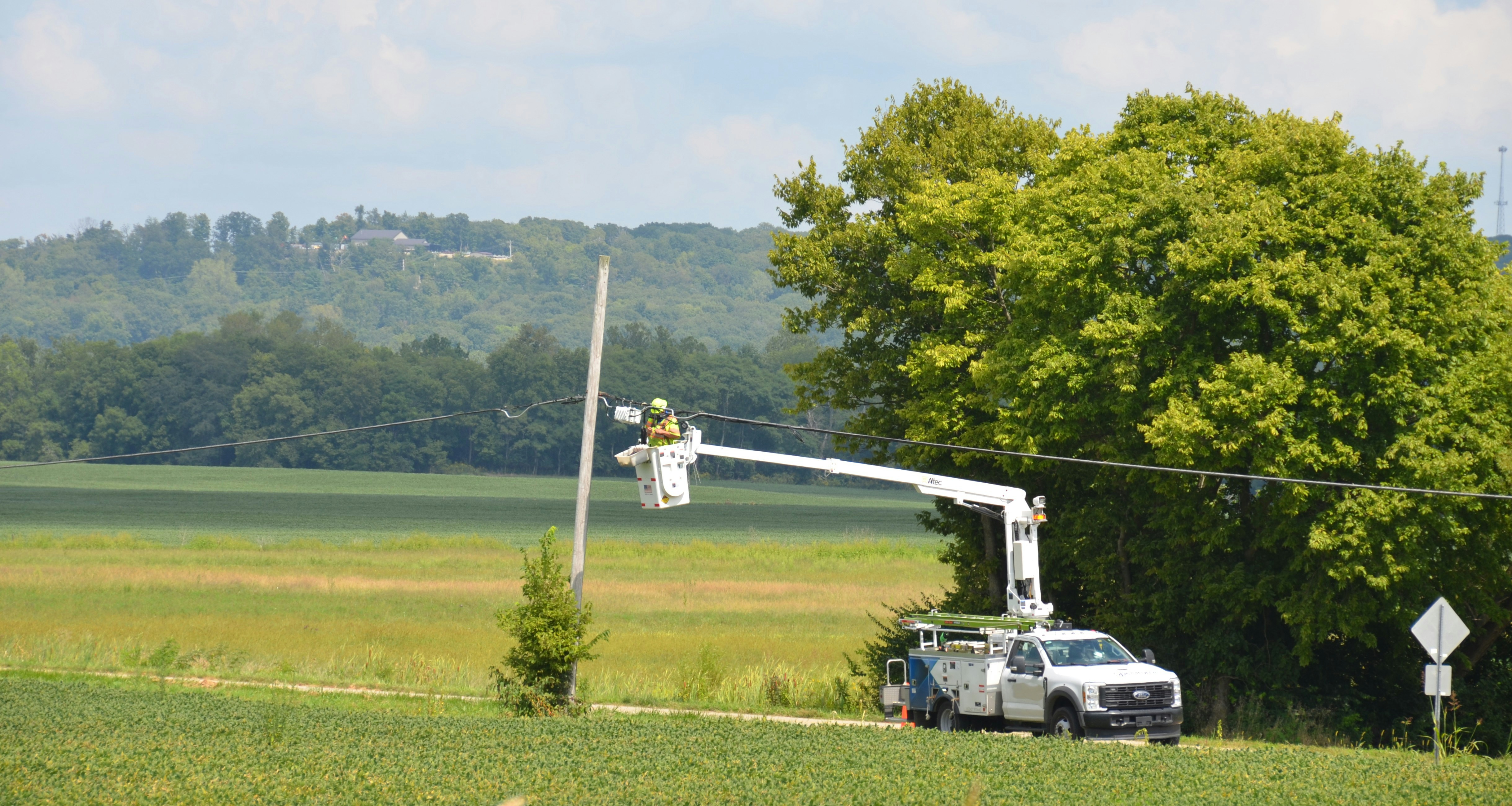 Pole, Bucket, and Field: A Work Truck at the Edge of the Green