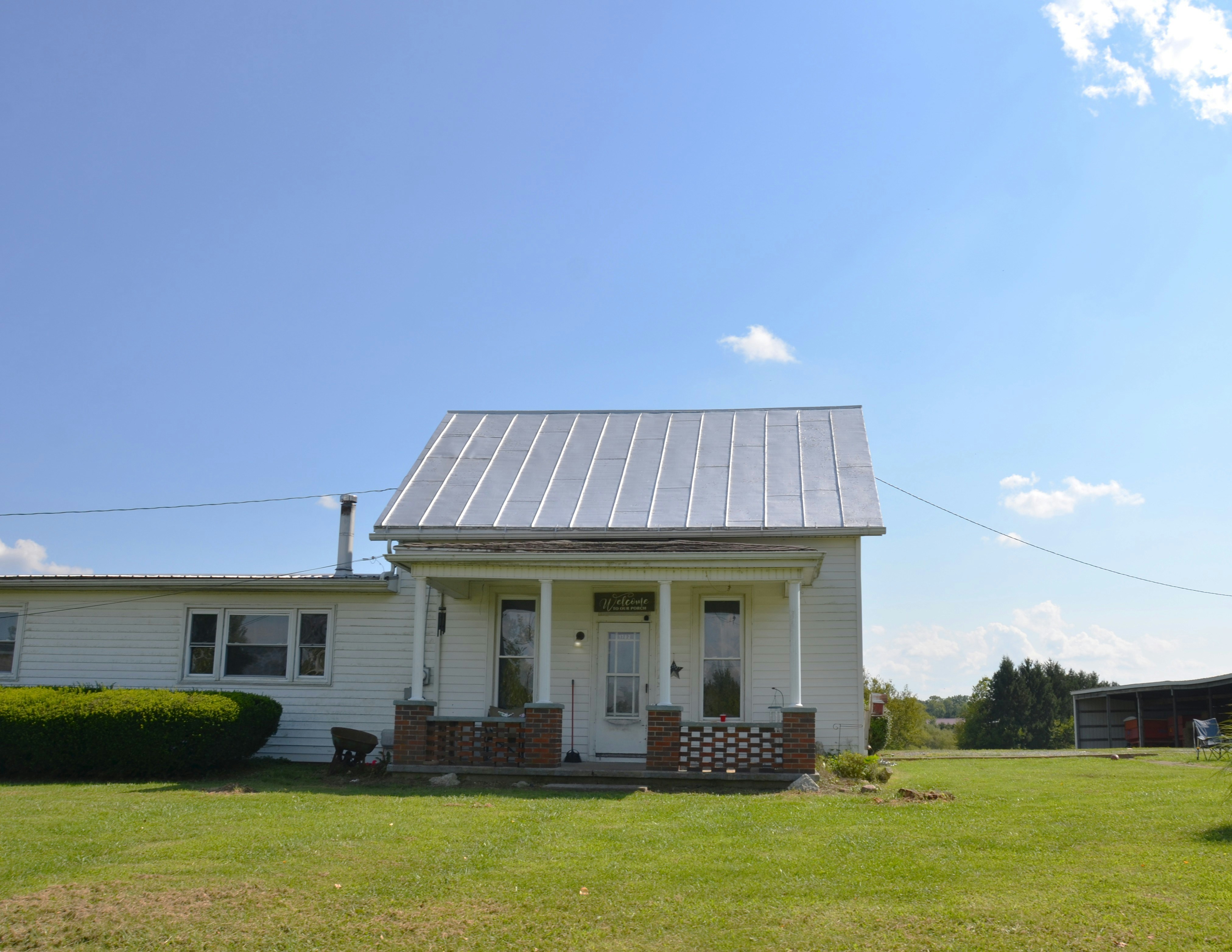 Cottage with Metal Roof: A Sunny Rural Home Under a Wide Arkansas Sky