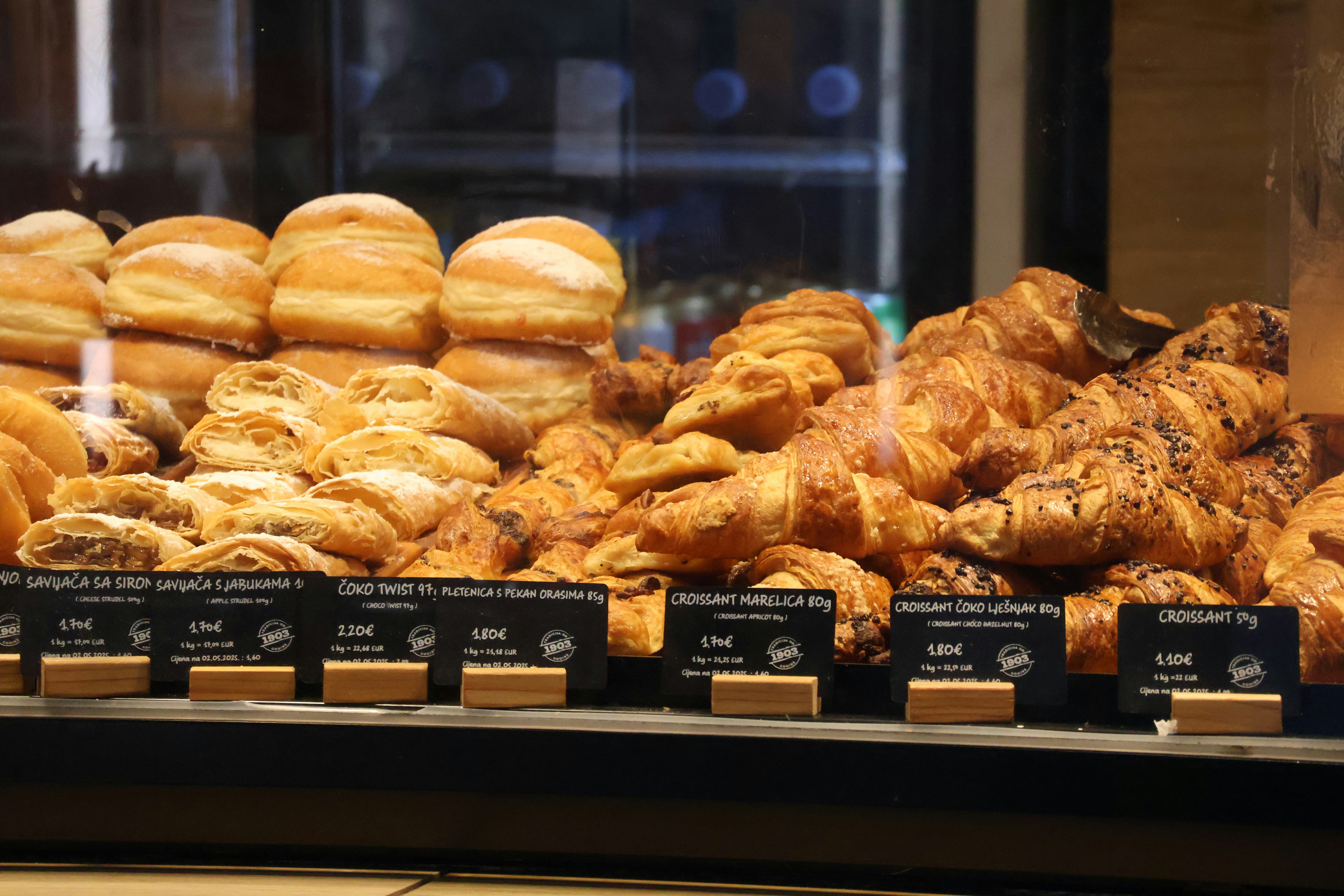 Golden Bakery Display: Assorted Pastries in a Glass Case
