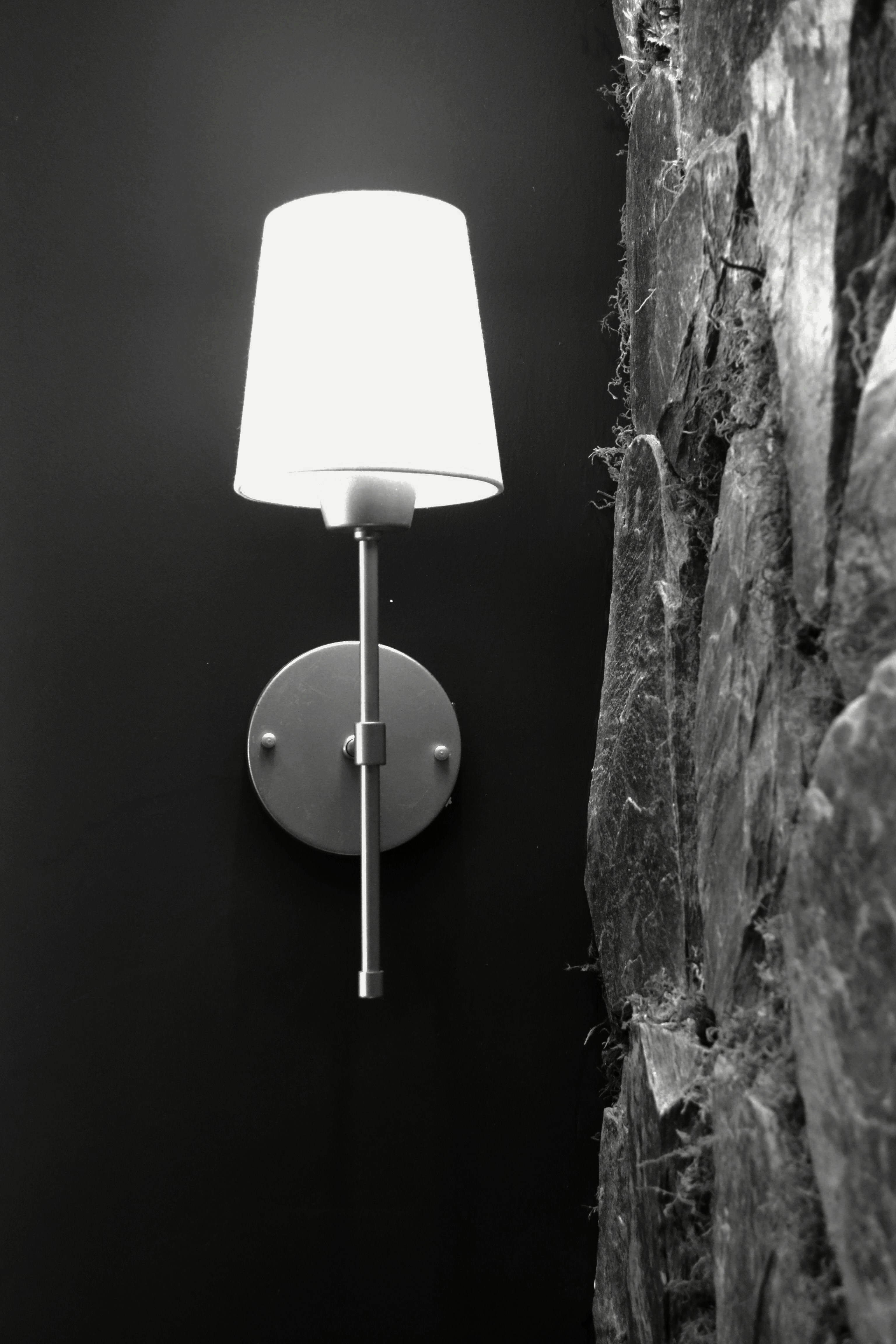 Illuminated Lamp Adrift on a Dark Wall