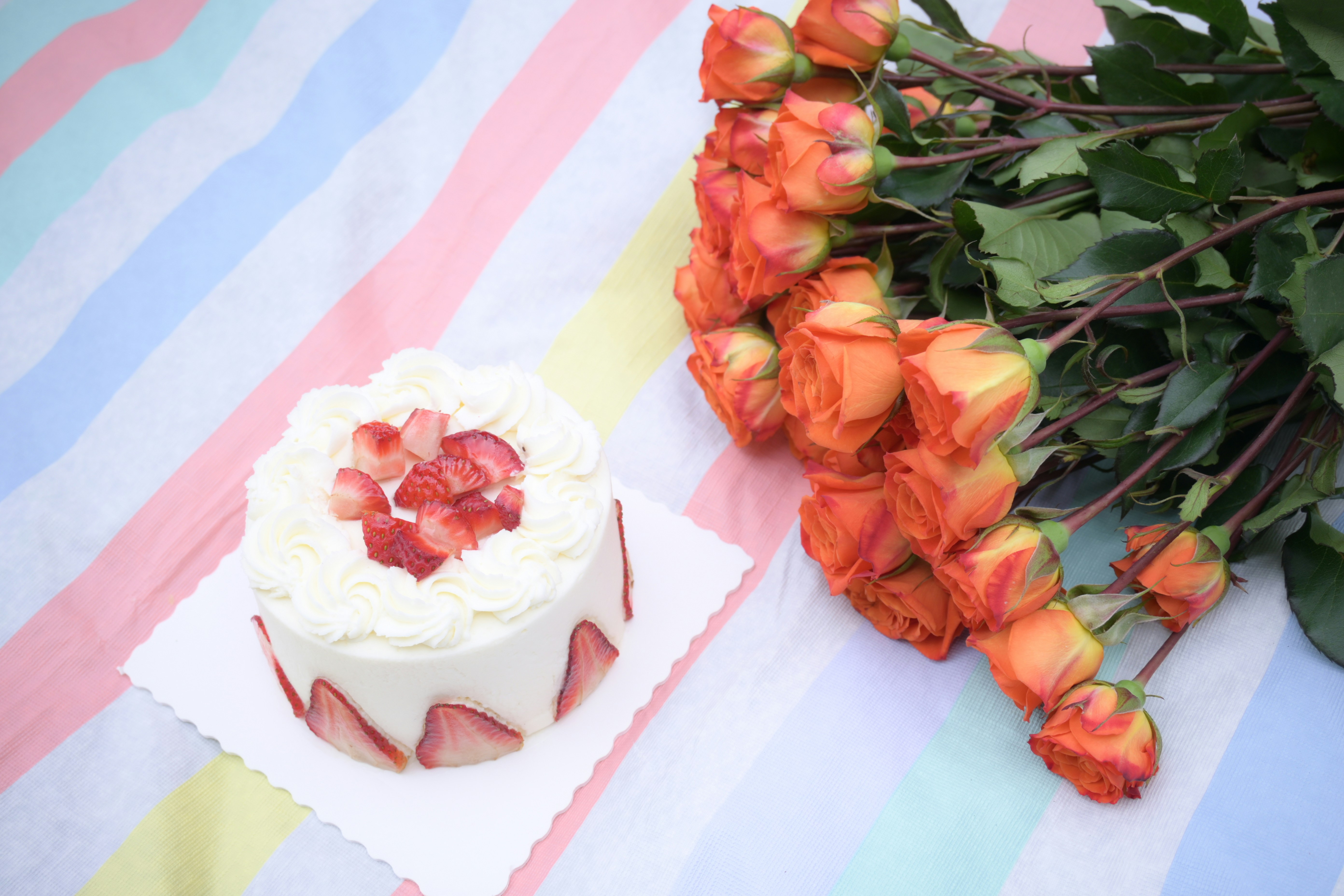Strawberry Frosted Celebration: A Cake and Bouquet on a Pastel Quilt