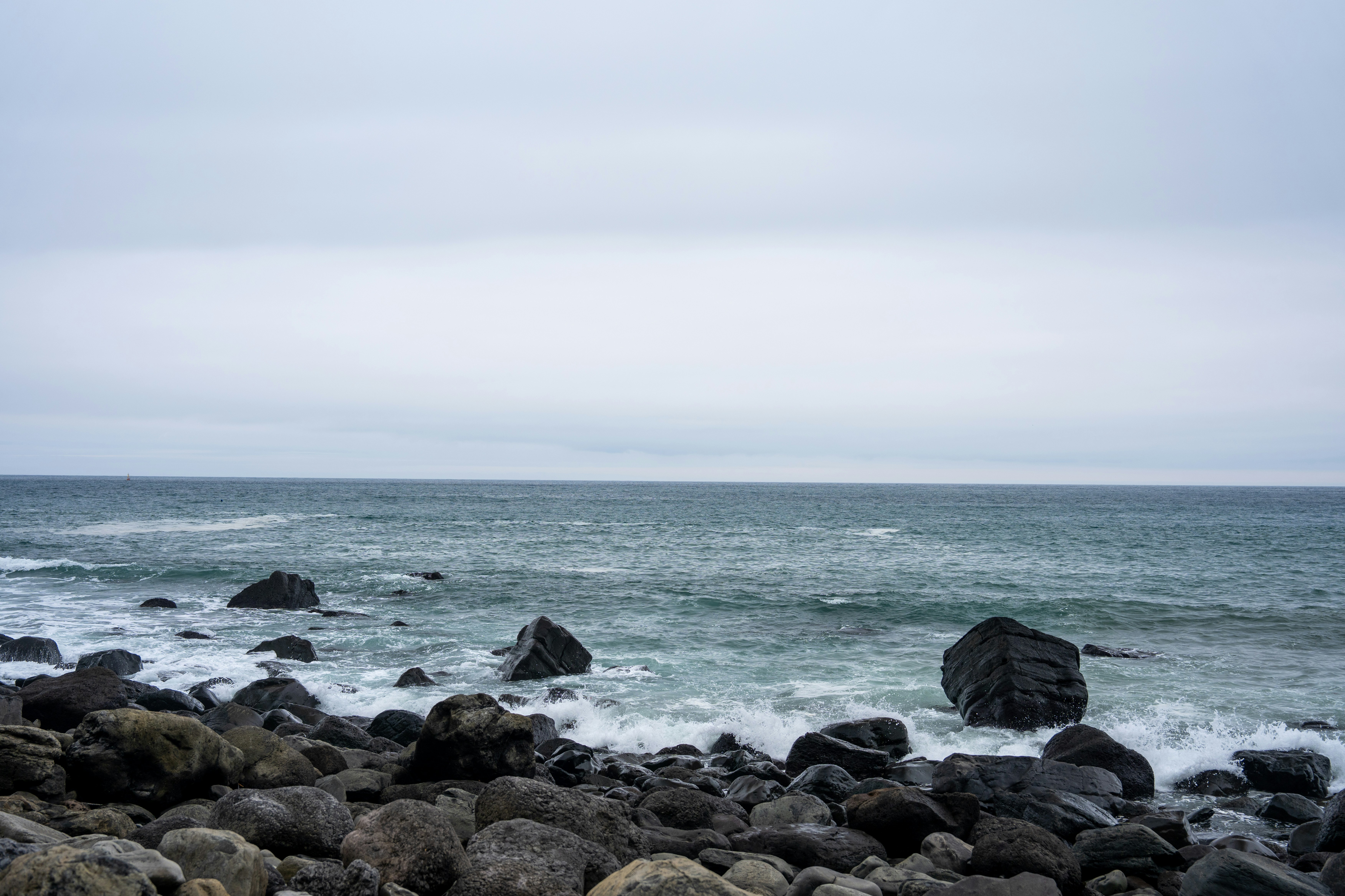 Rugged shoreline under a quiet, overcast sky
