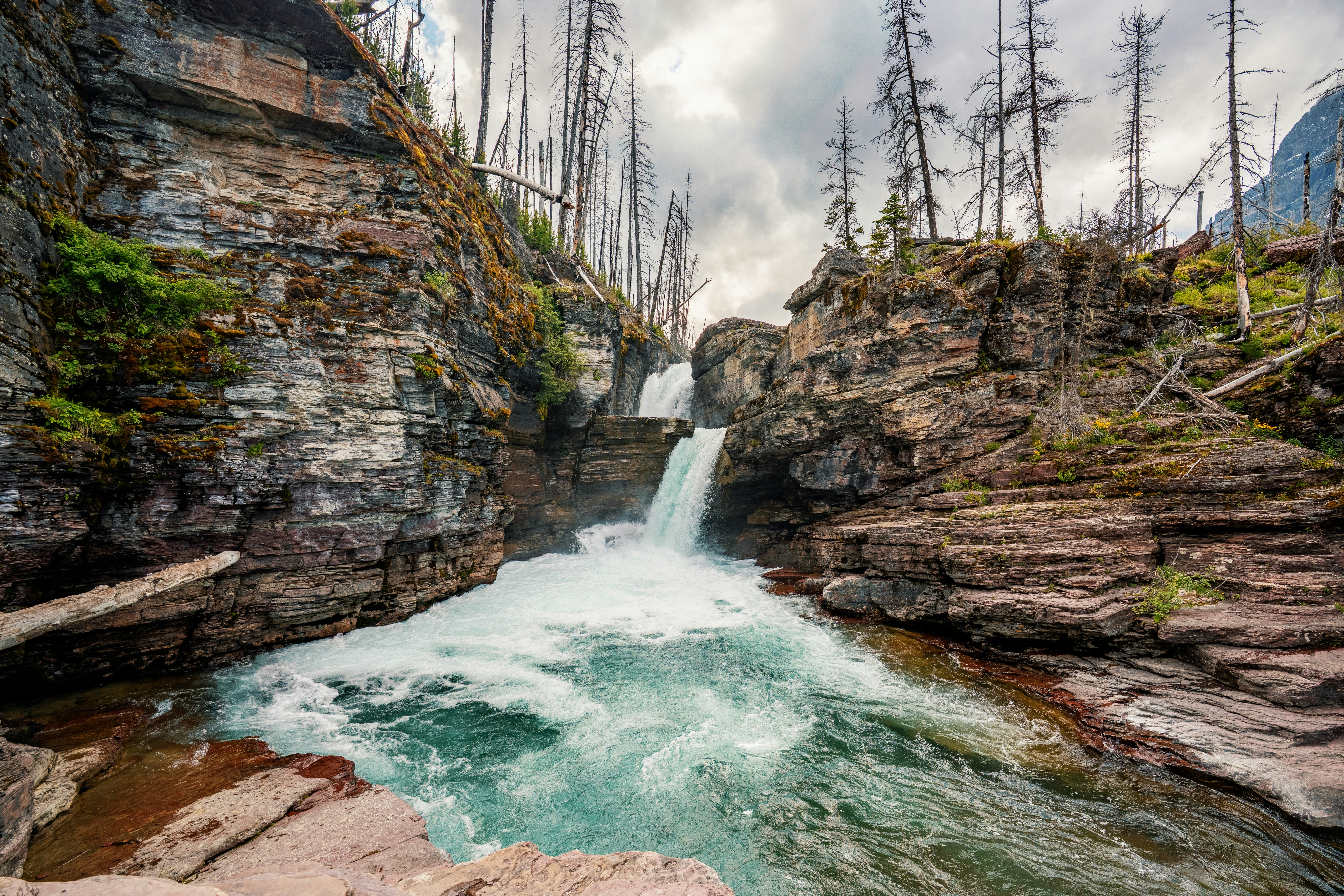 Rugged Gorge Cascade Between Layered Red Walls