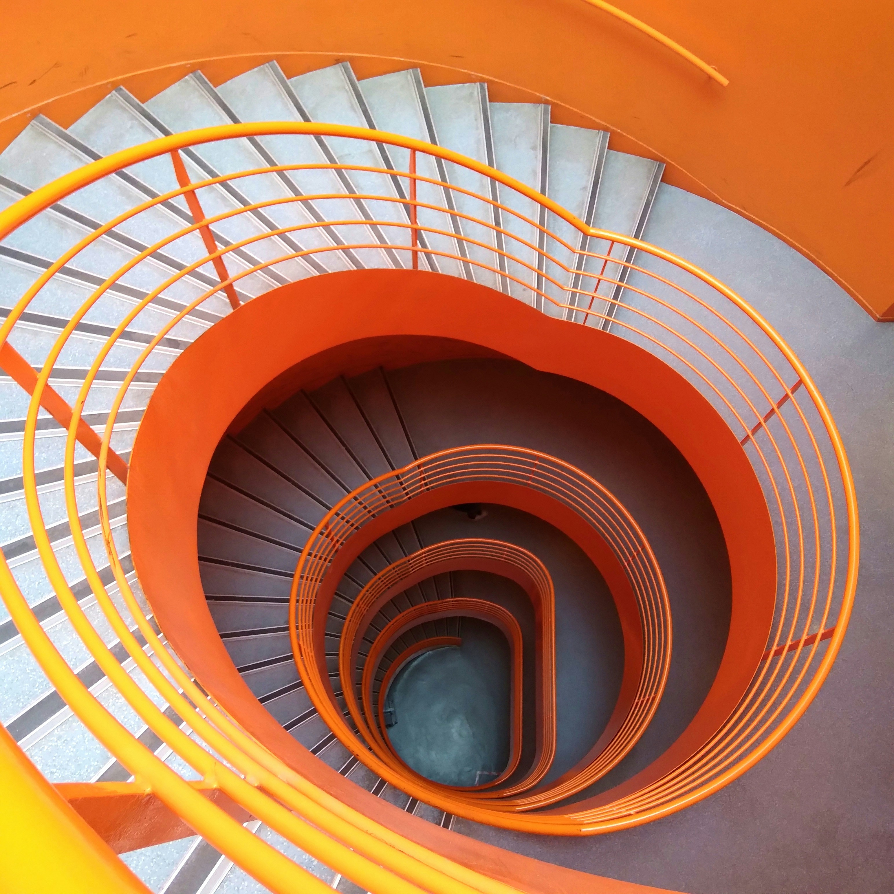 Spiral Ascent: A Vivid Orange Descent Through Circular Ribbons