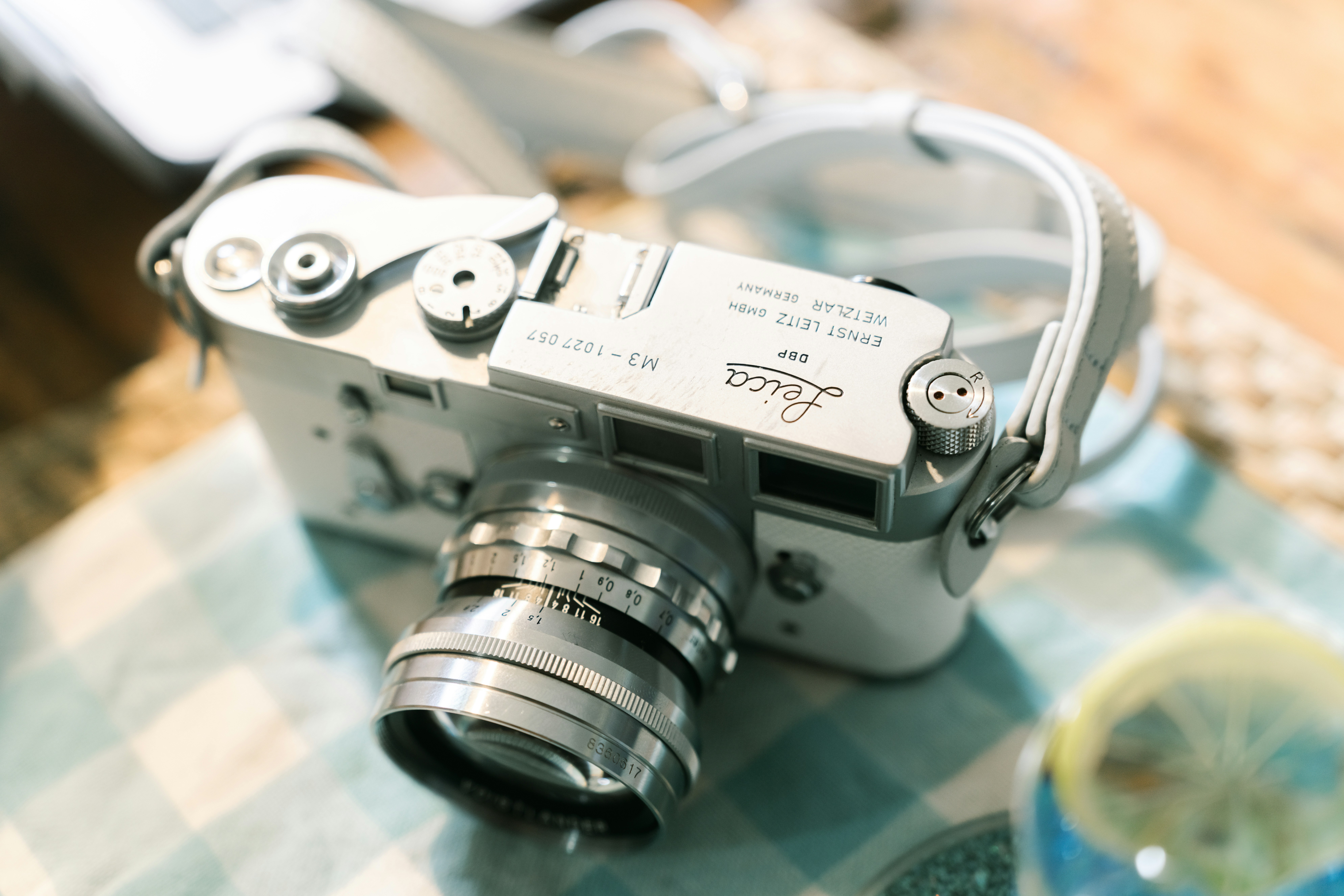 Vintage silver mirror: a Leica-like rangefinder resting on a checkered cloth