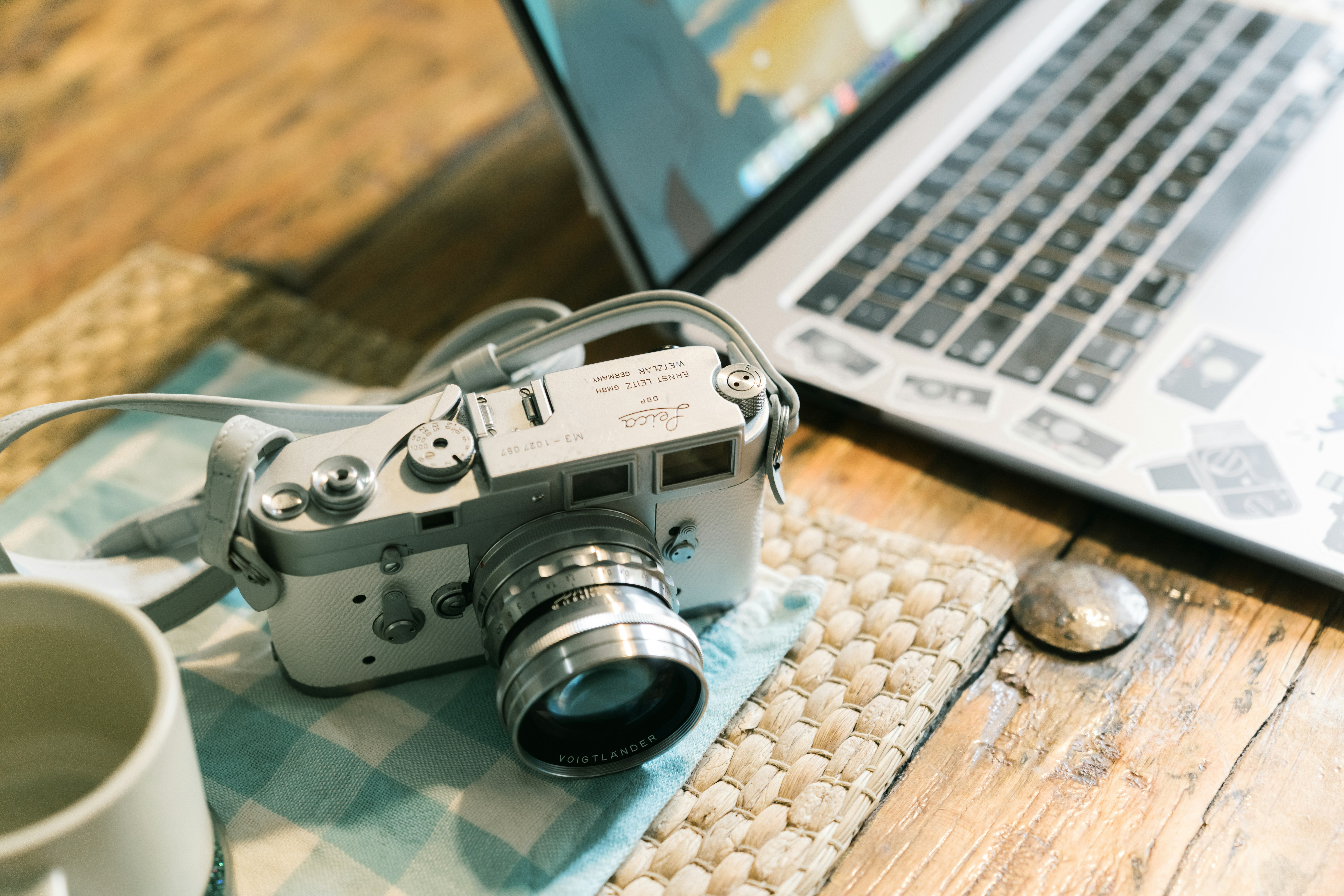 Flat-lay with a Mirror of Moments: A vintage camera beside a laptop