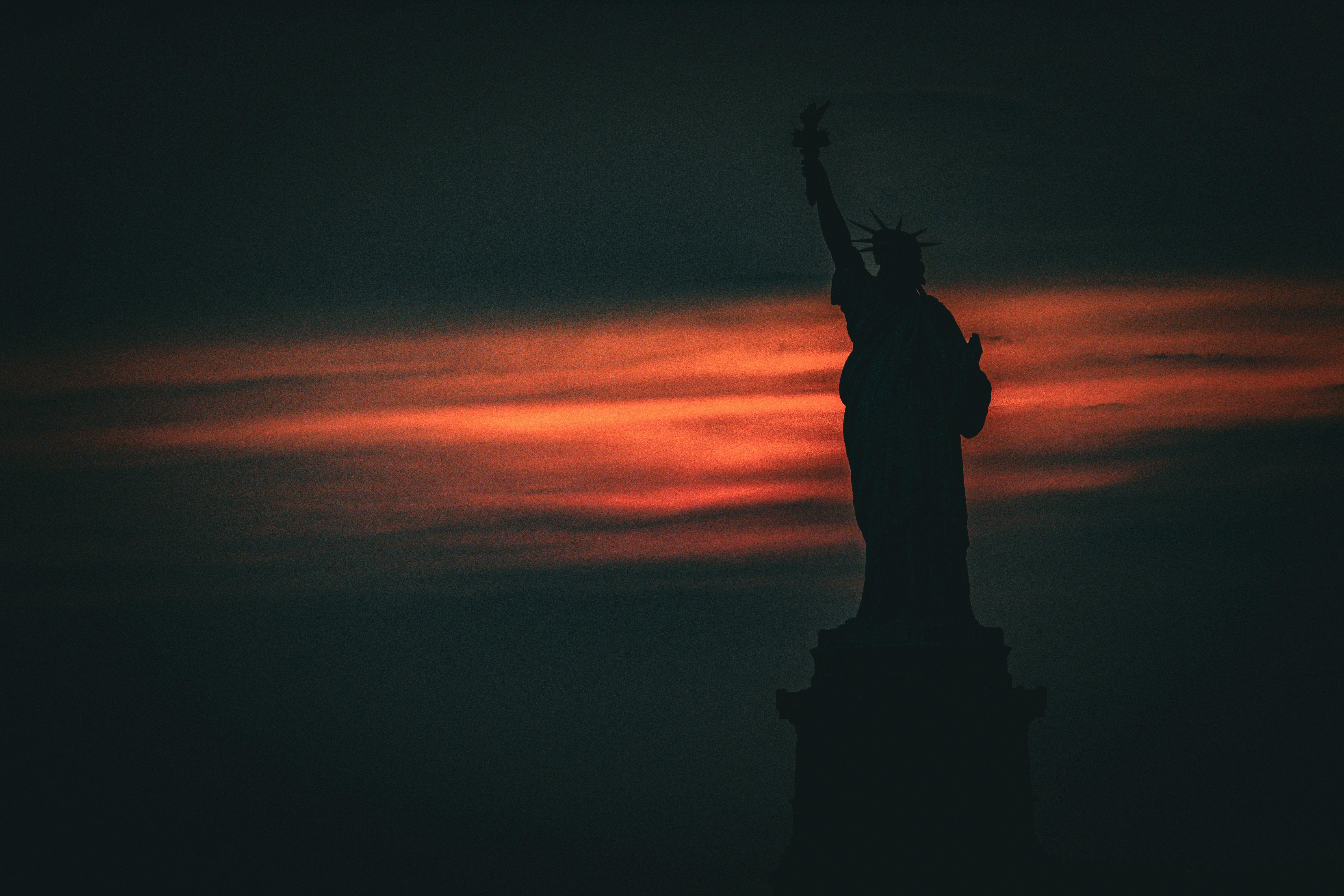 Silhouette of Liberty Against a Fiery Dusk