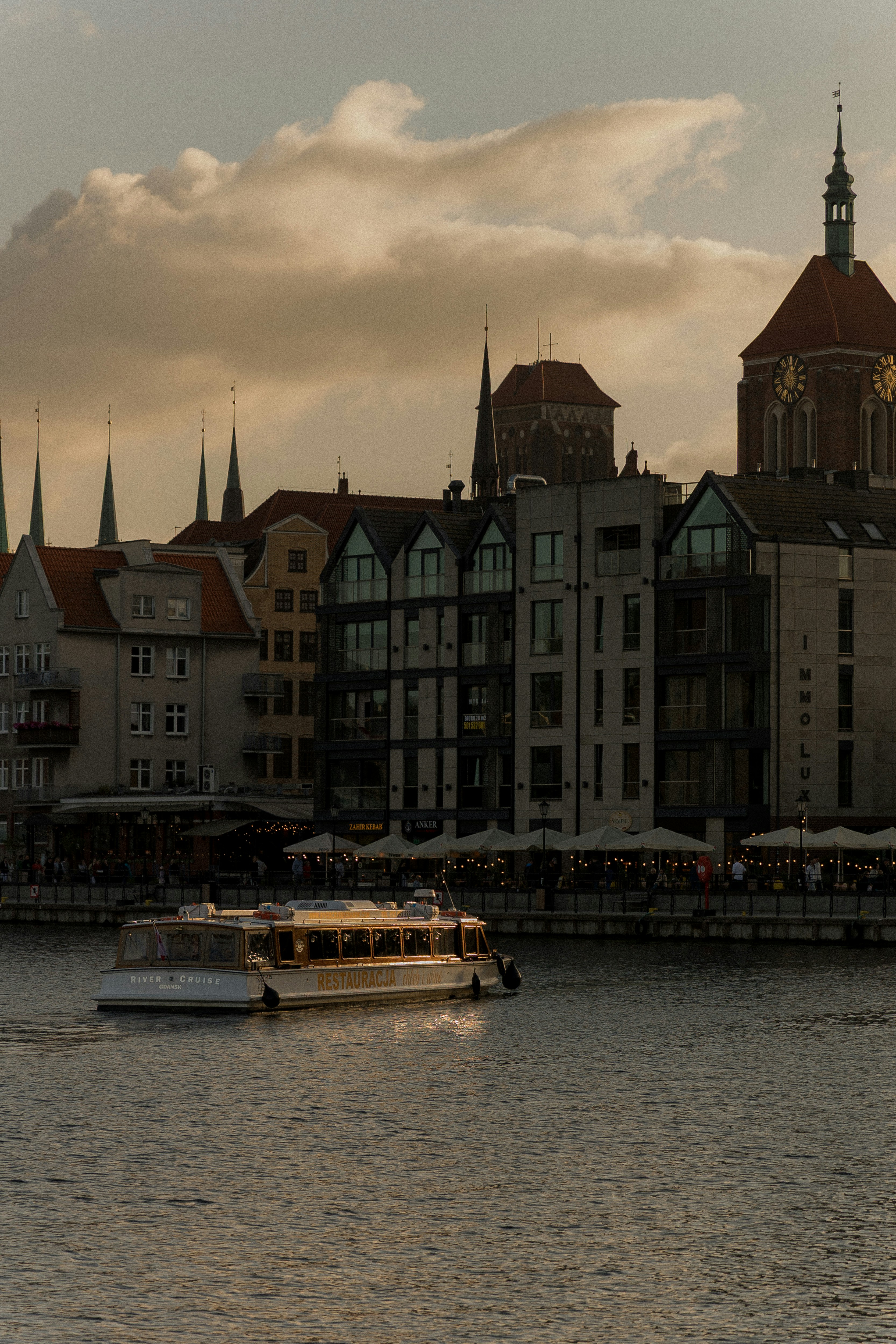 Harbor Sunset Ascent: A Riverside Boat Slips Through Historic Dusk