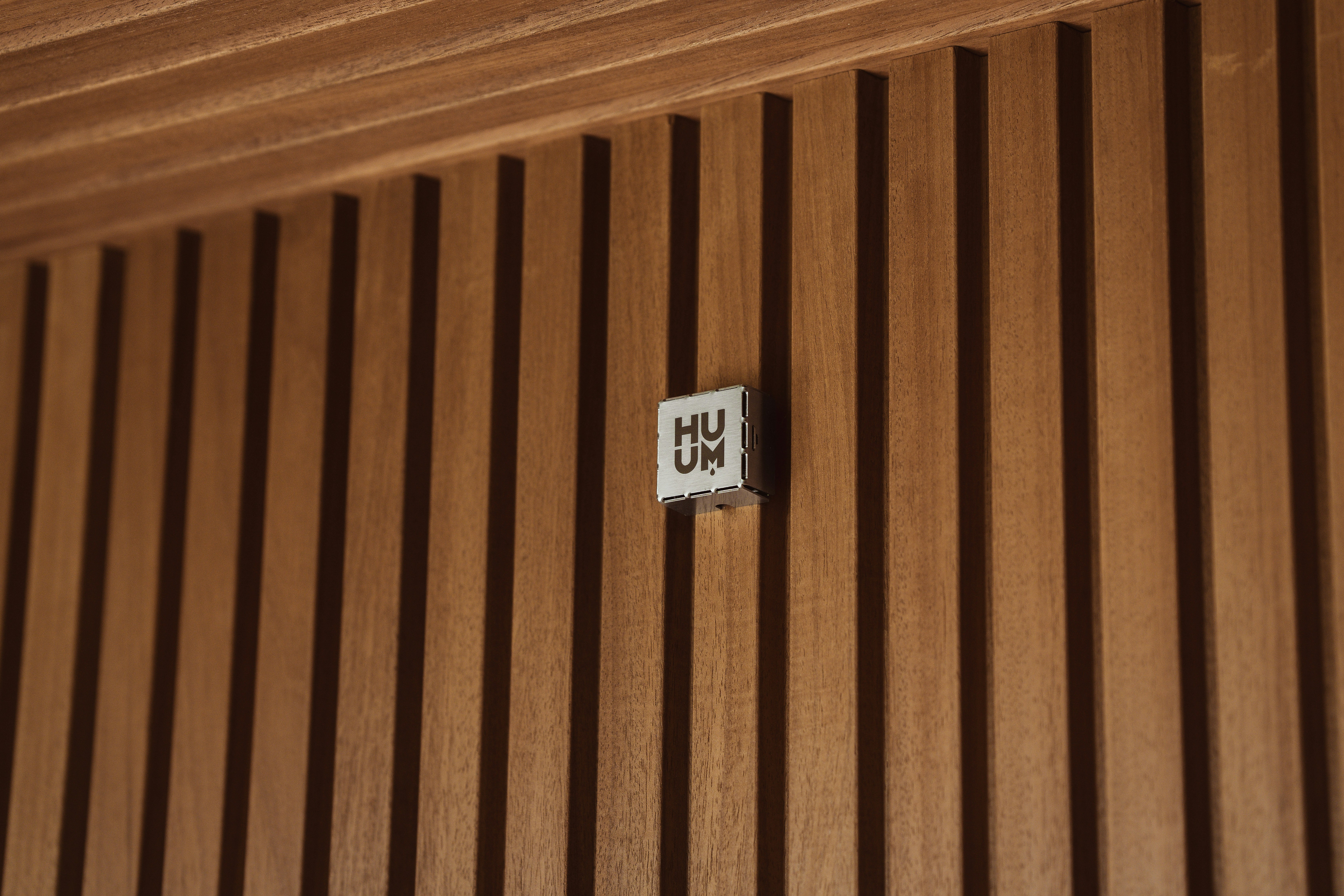 Wooden wall rhythms meet a tiny sign: HUM on the wall