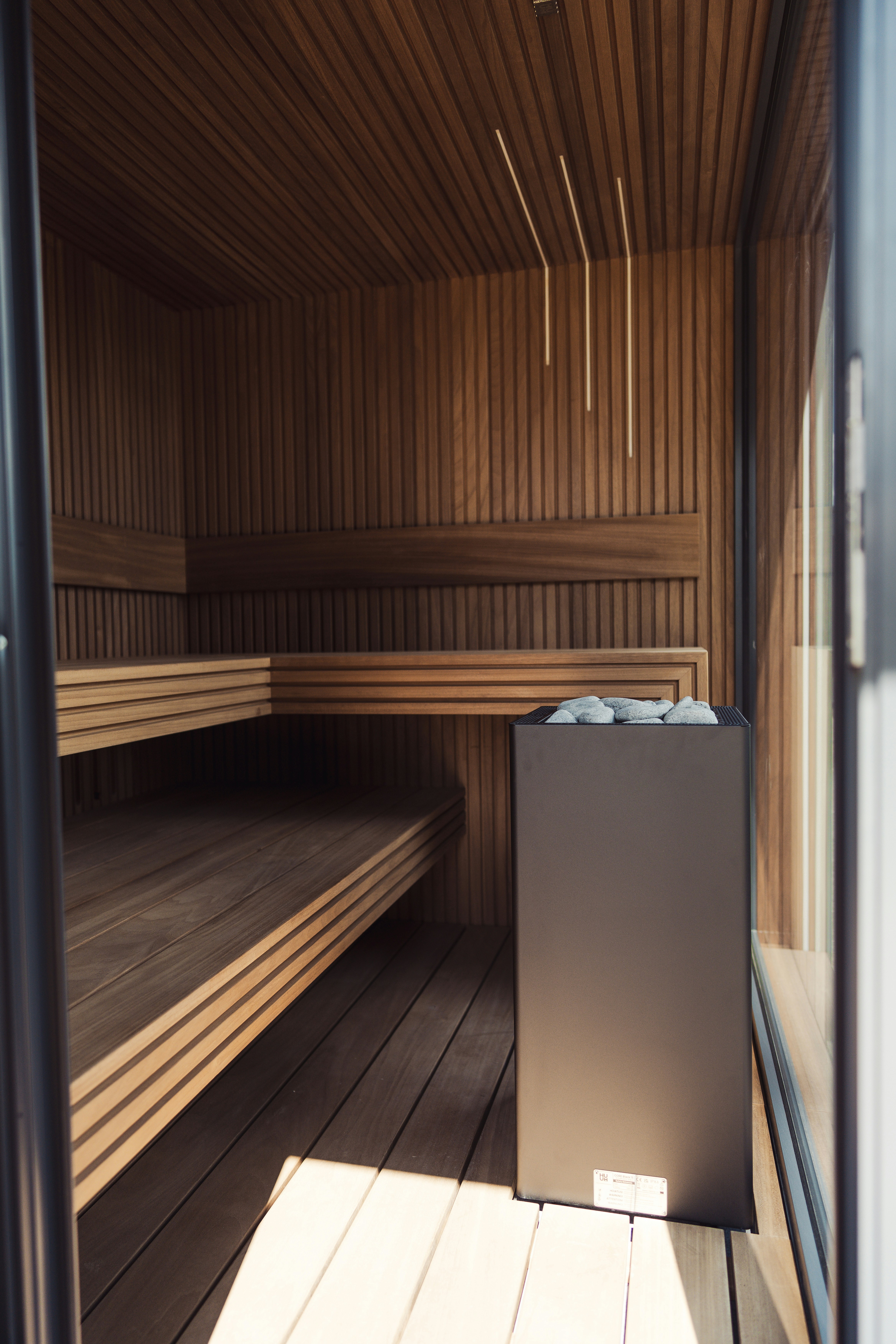 Warm Lines: Sunset-Tinted Sauna with Cedar Slats