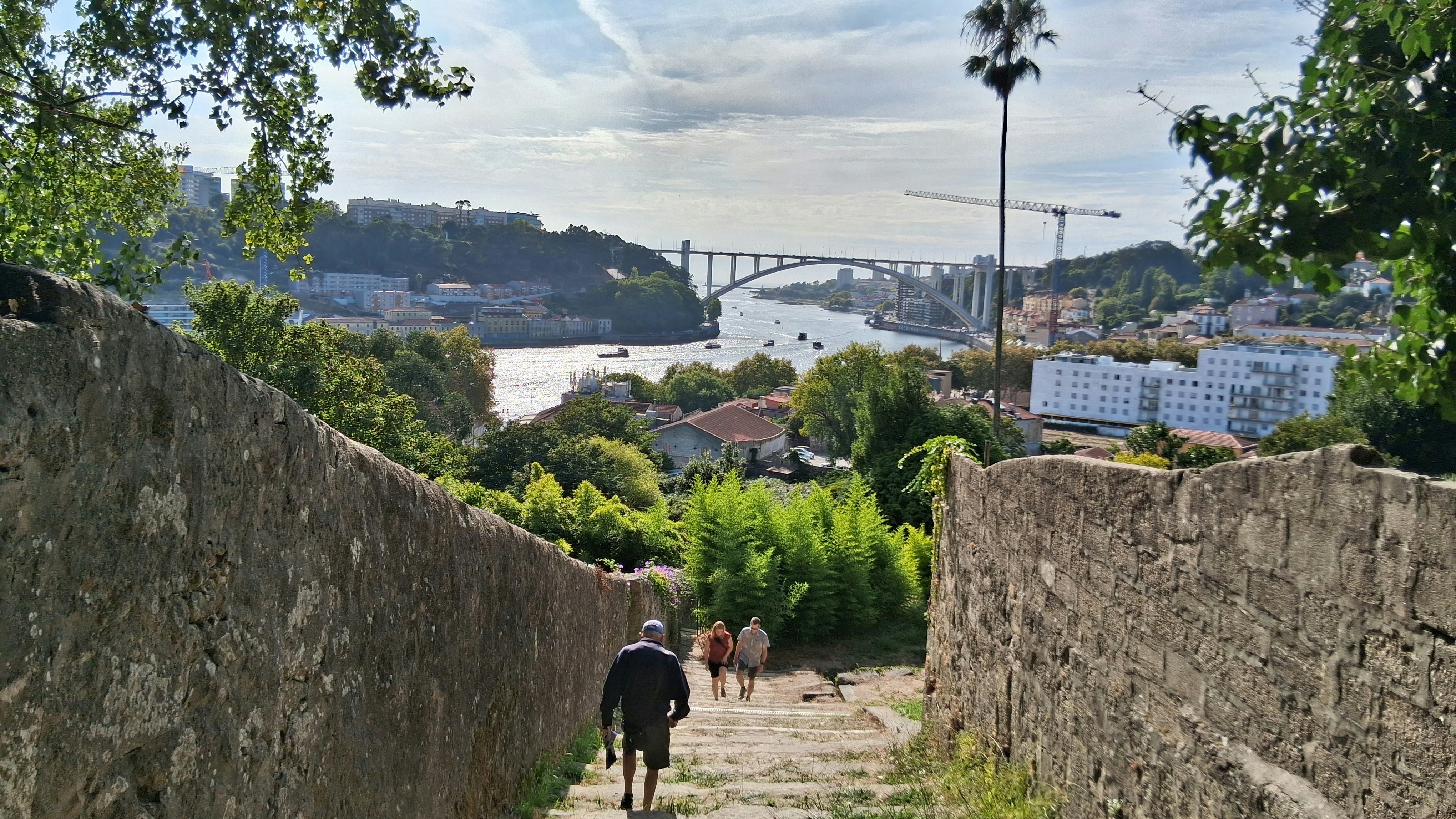 Path to the Bridge: hikers descend the ancient stone ramp toward a riverside panorama